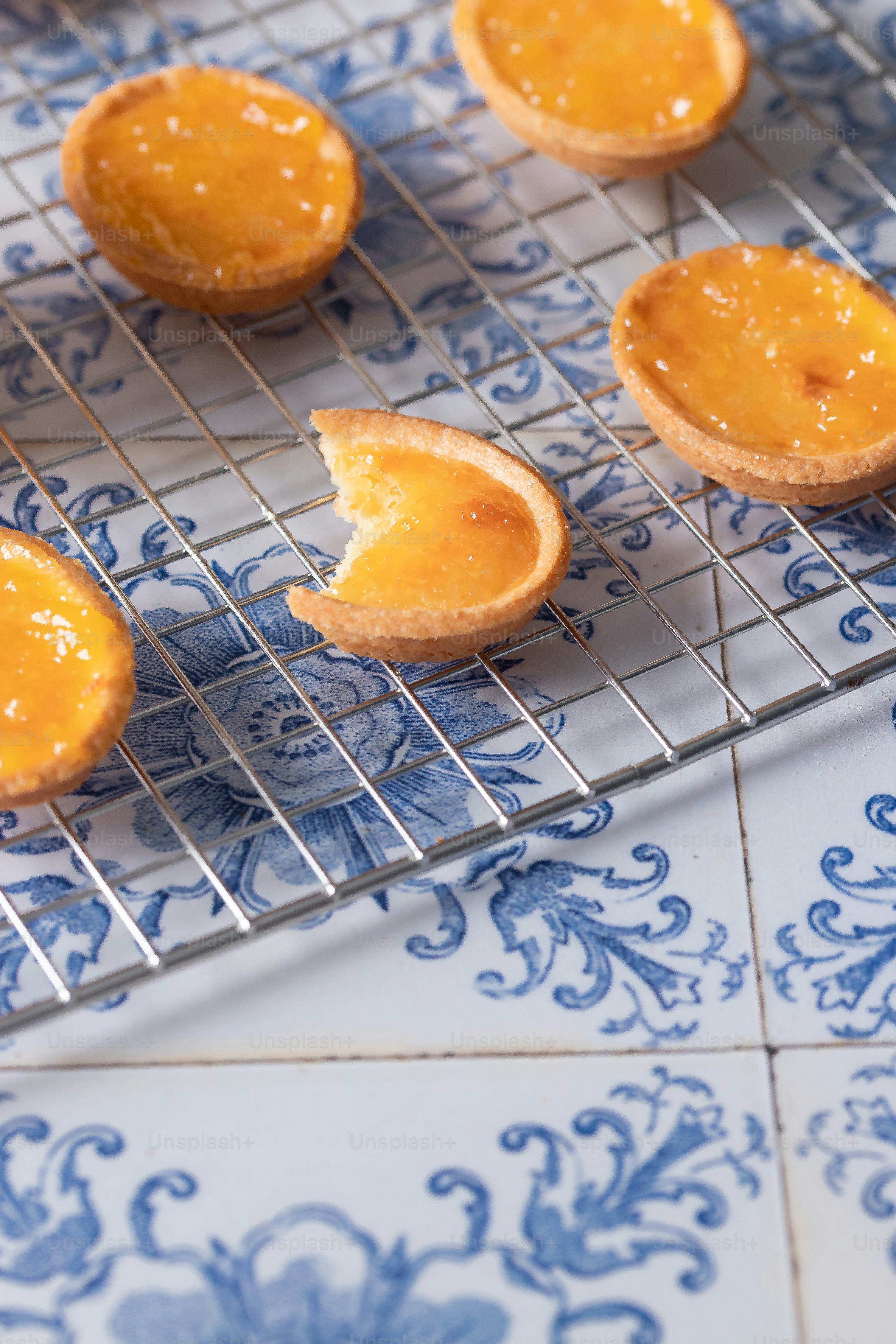 A cooling rack with a bunch of pastries on it photo – Custard Image on ...