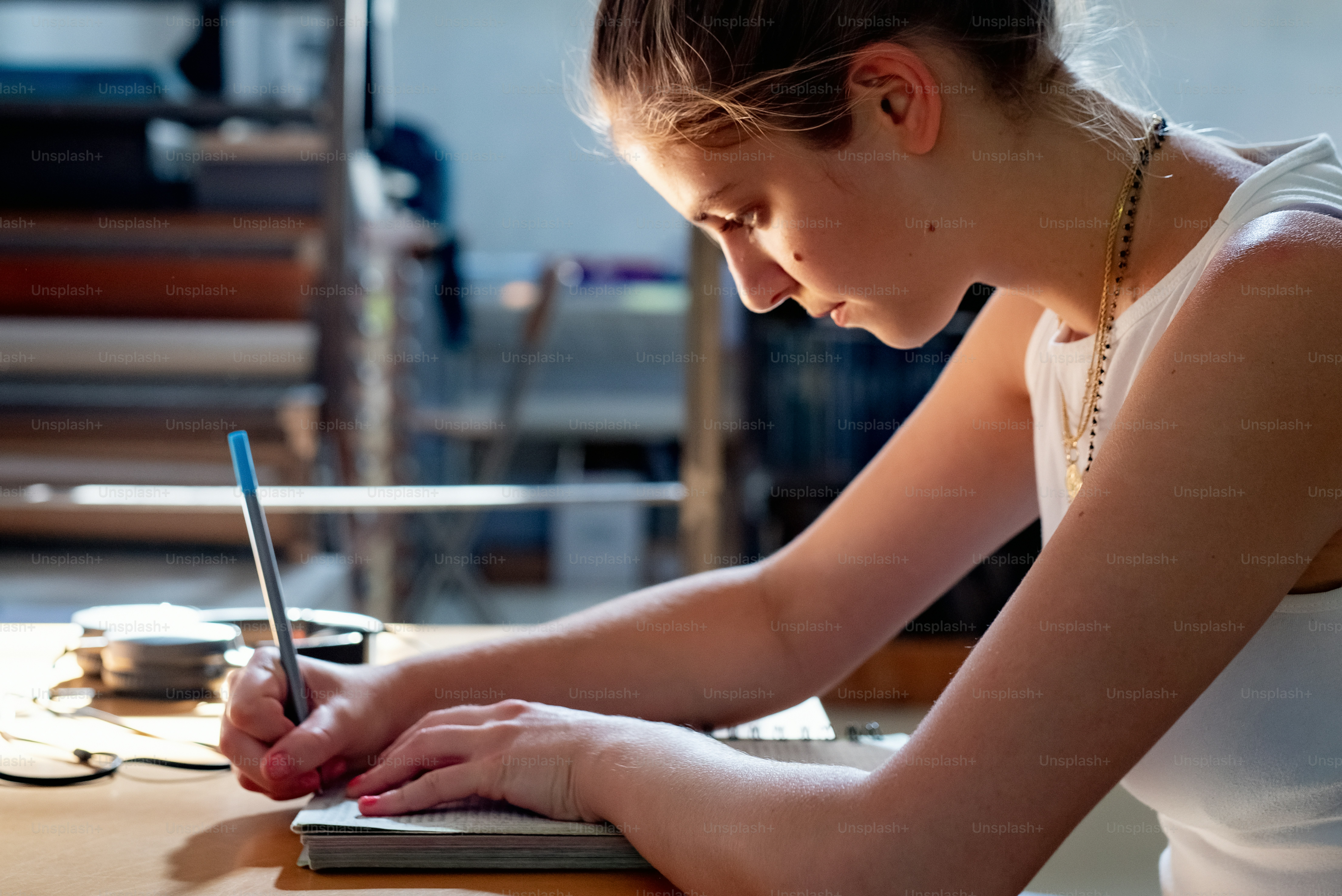A woman writing on a notebook with a pen photo – Woman Image on Unsplash