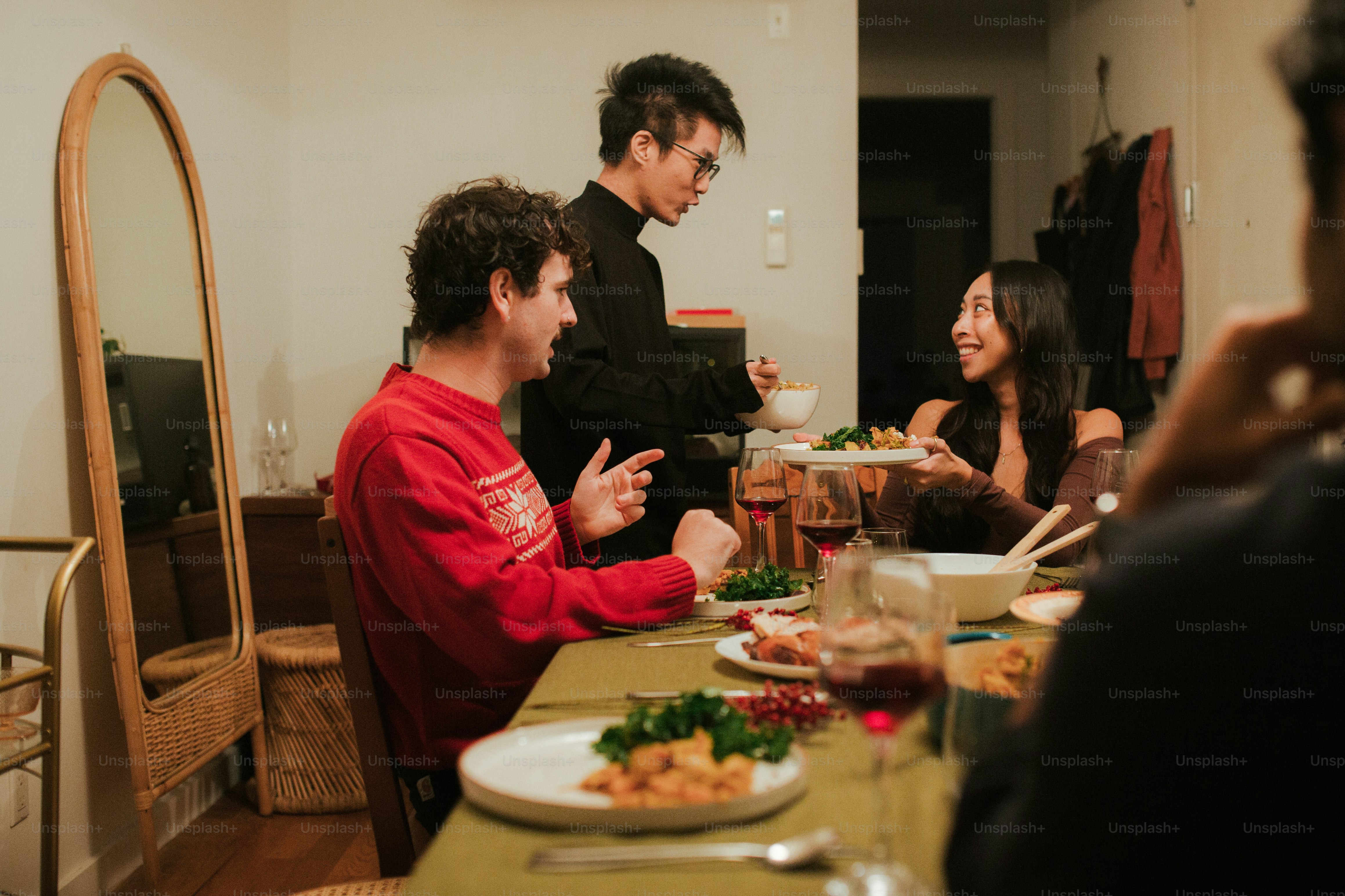 A group of people sitting around a dinner table photo – Host Image on ...