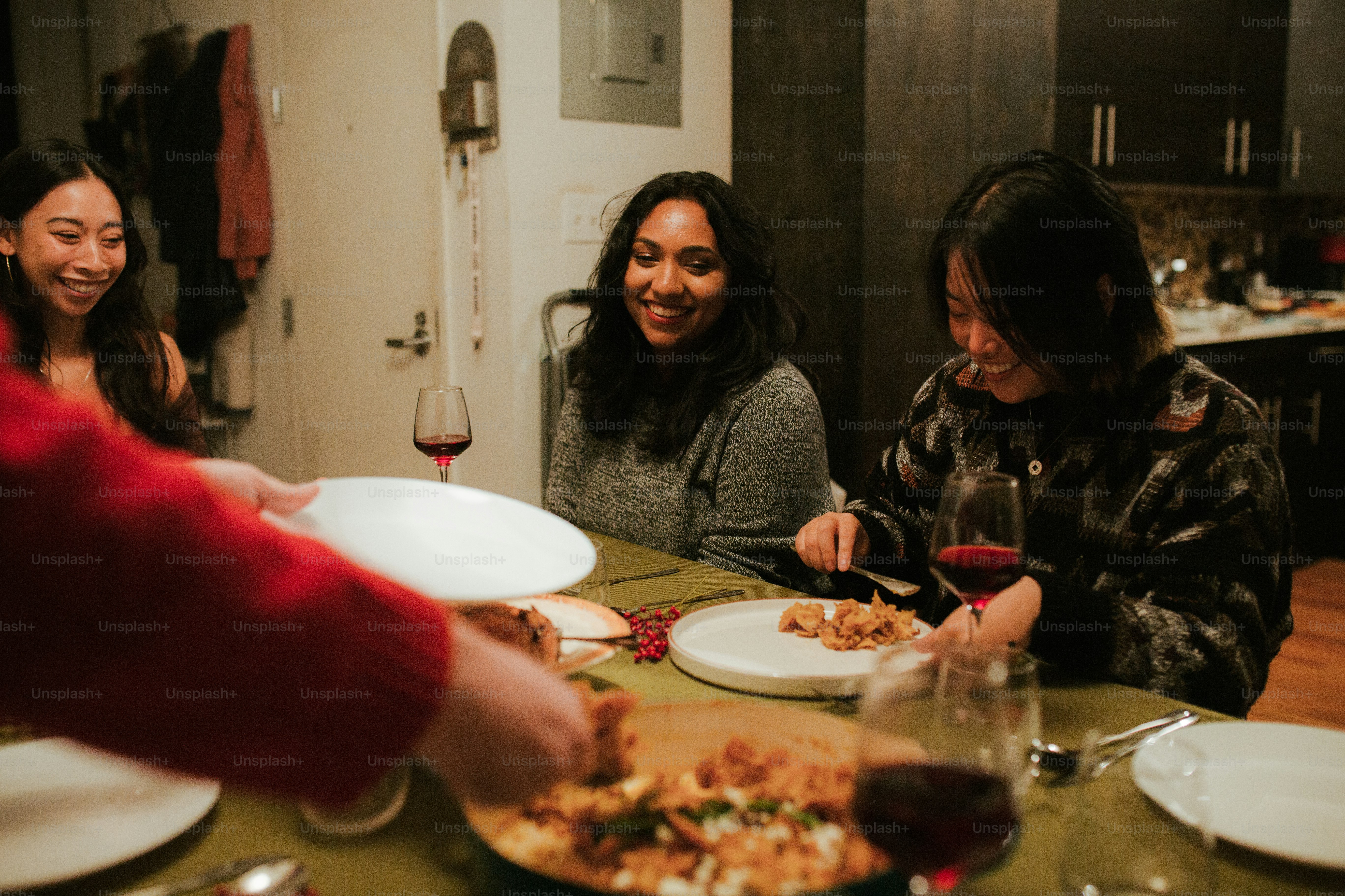 A group of people sitting around a table with plates of food photo ...