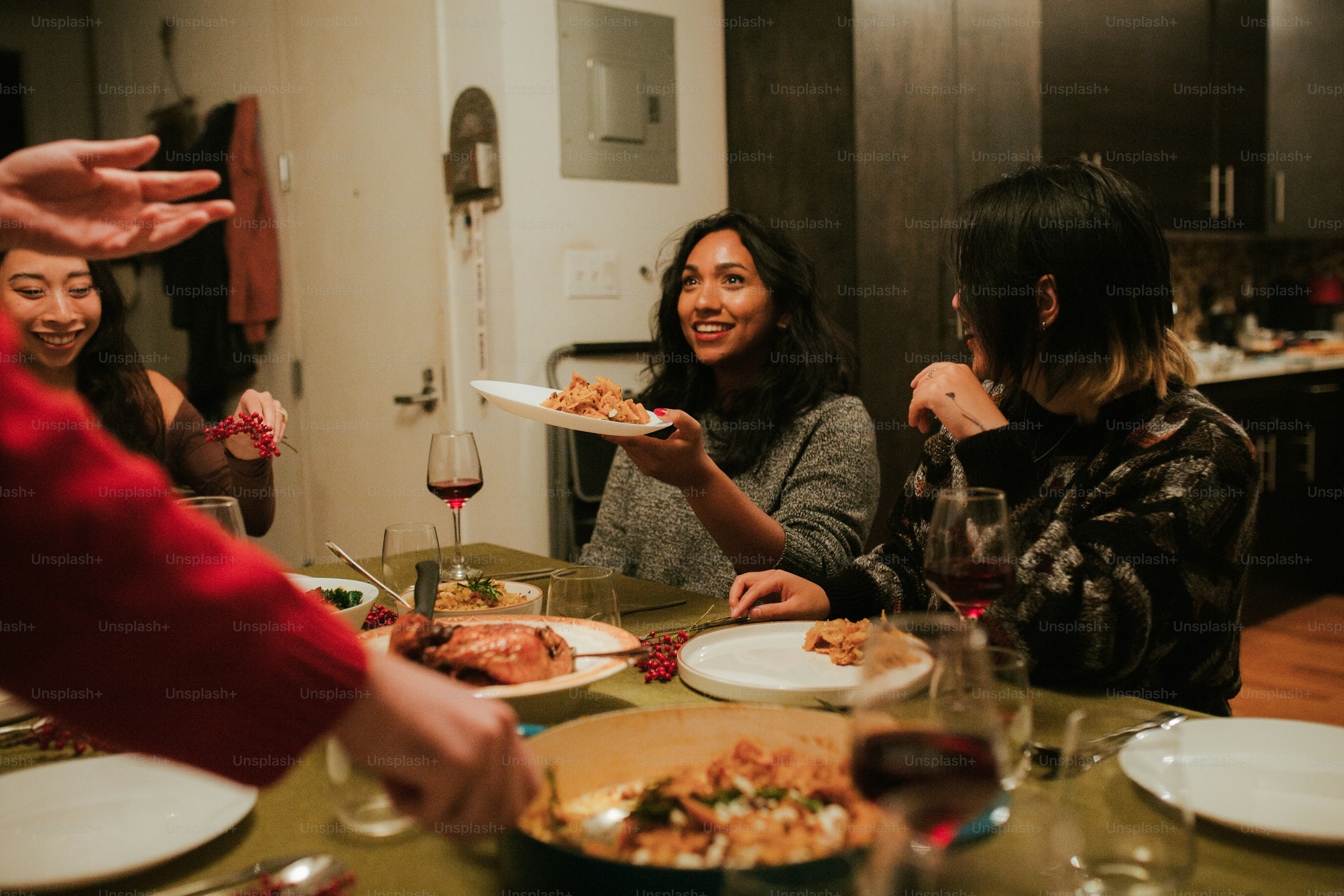 Un groupe de personnes assises autour d’une table en train de manger de ...