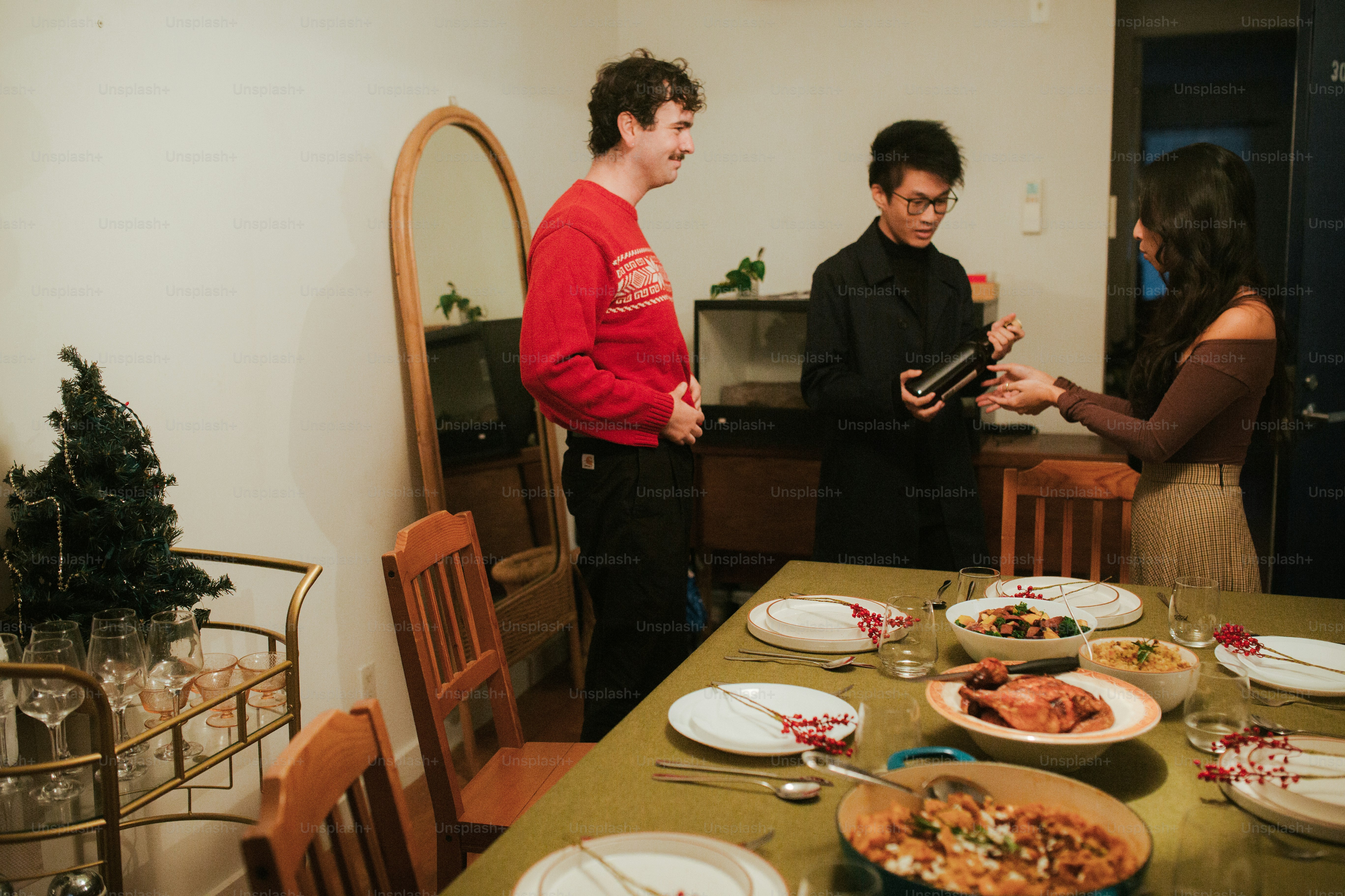 A group of people standing around a dining room table photo – Meal ...