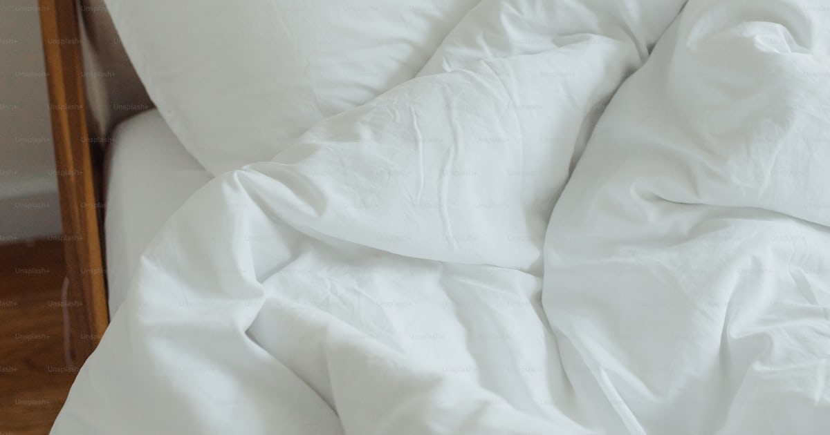 하얀 시트와 베개가 있는 정돈되지 않은 침대 사진 Unsplash의 침대 이미지