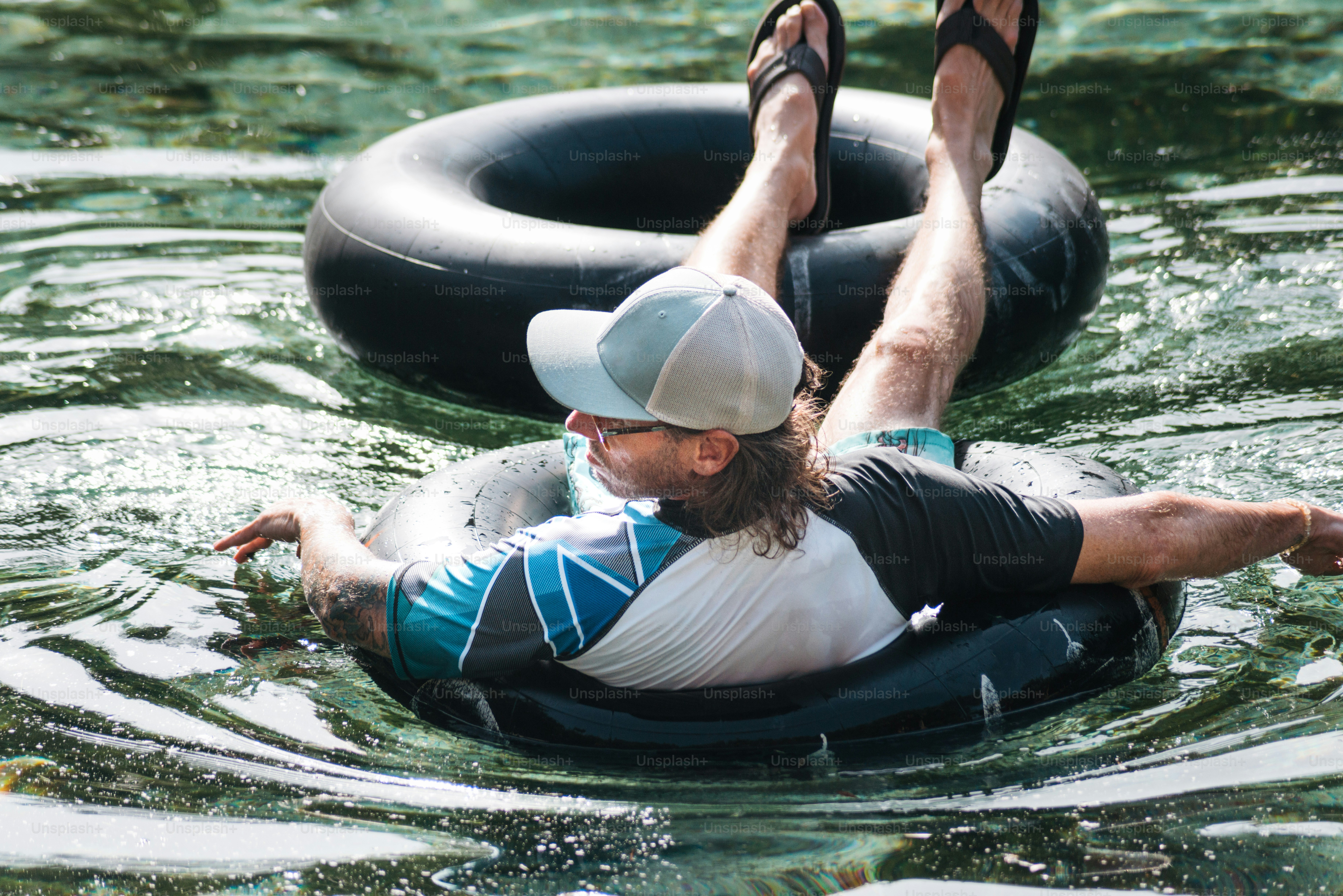 A man laying on an inner tube in the water photo – Floaty Image on Unsplash