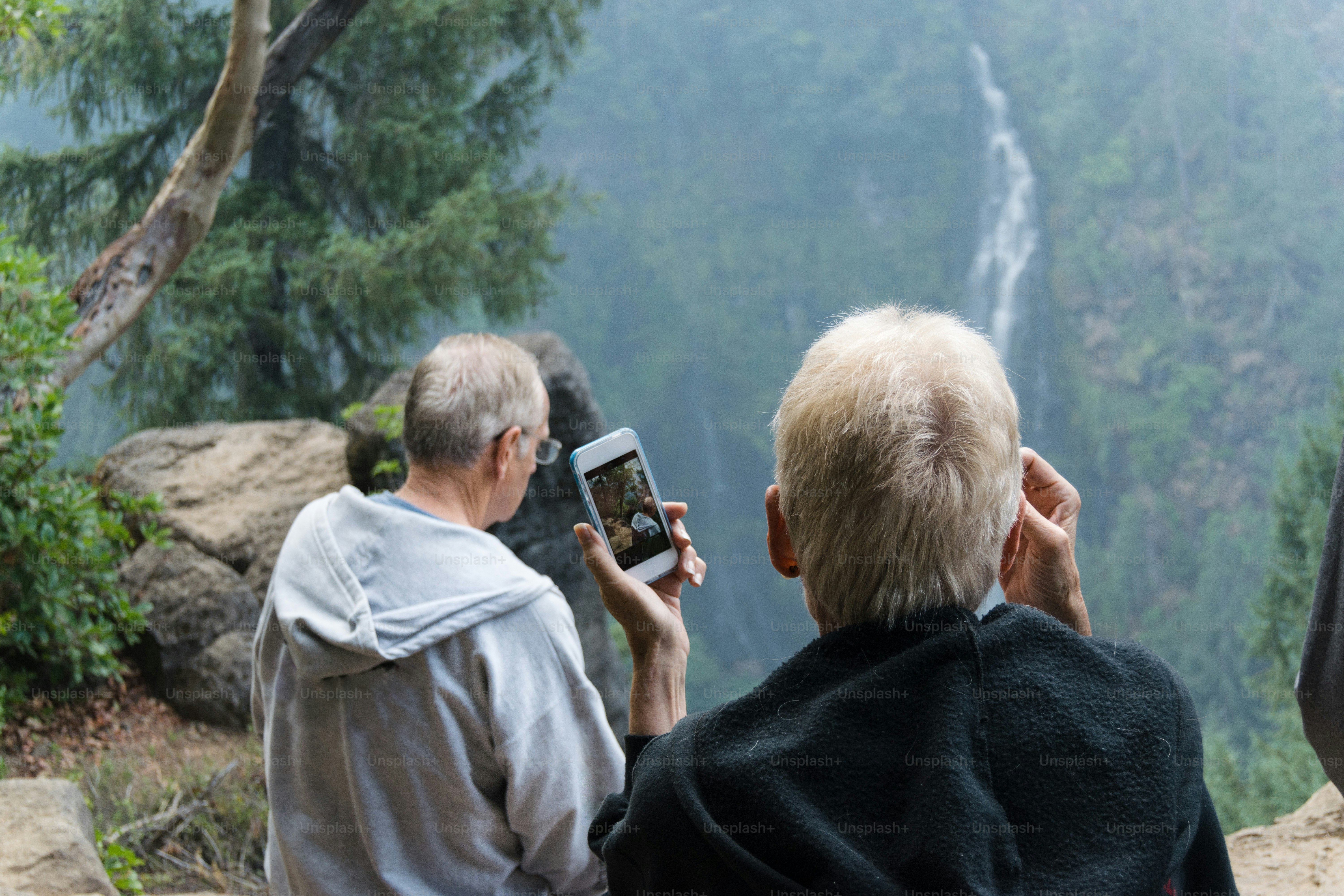 Un homme et une femme prenant une photo d’une cascade photo – Les ...