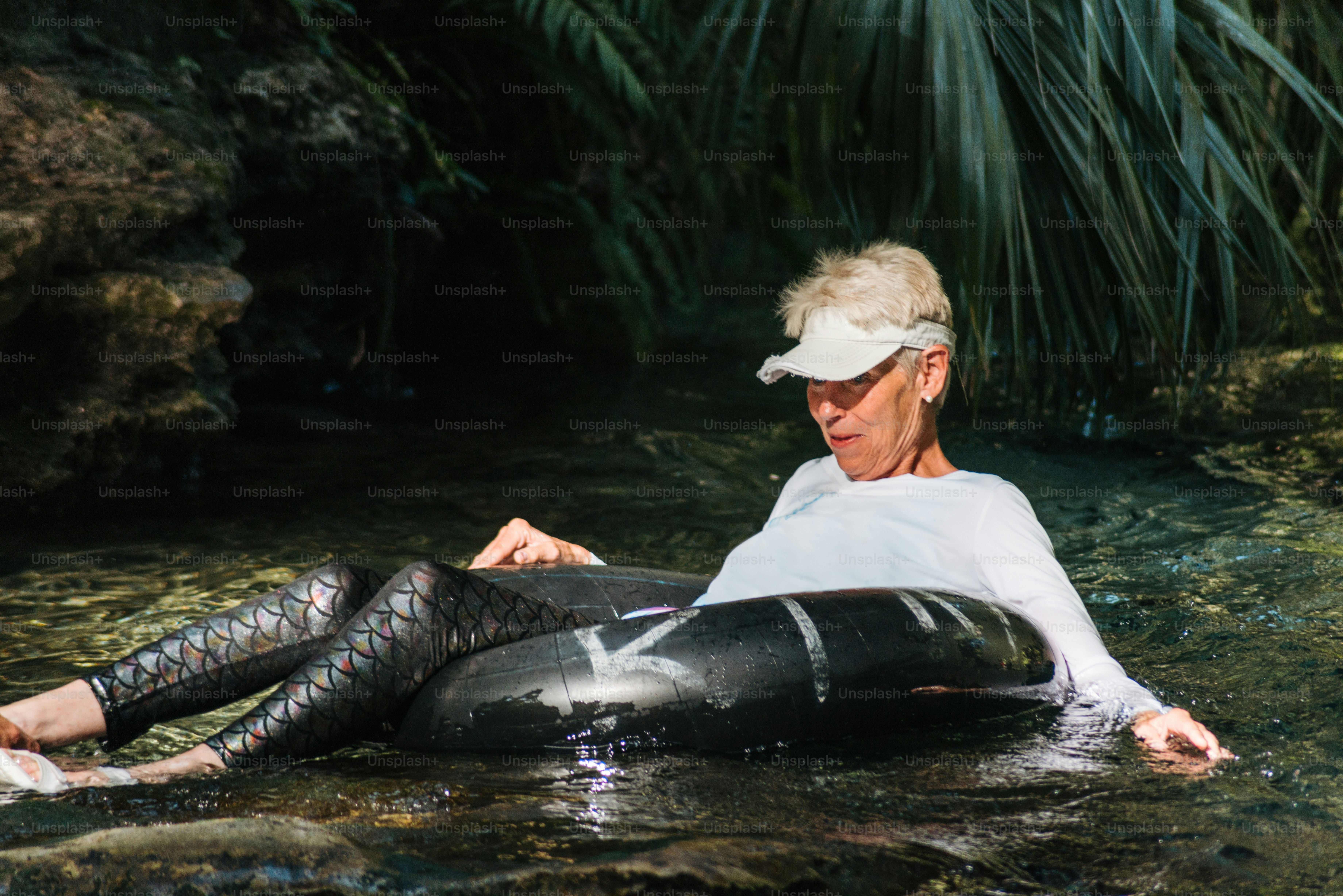 A woman laying on top of a body of water photo – Rafting Image on Unsplash