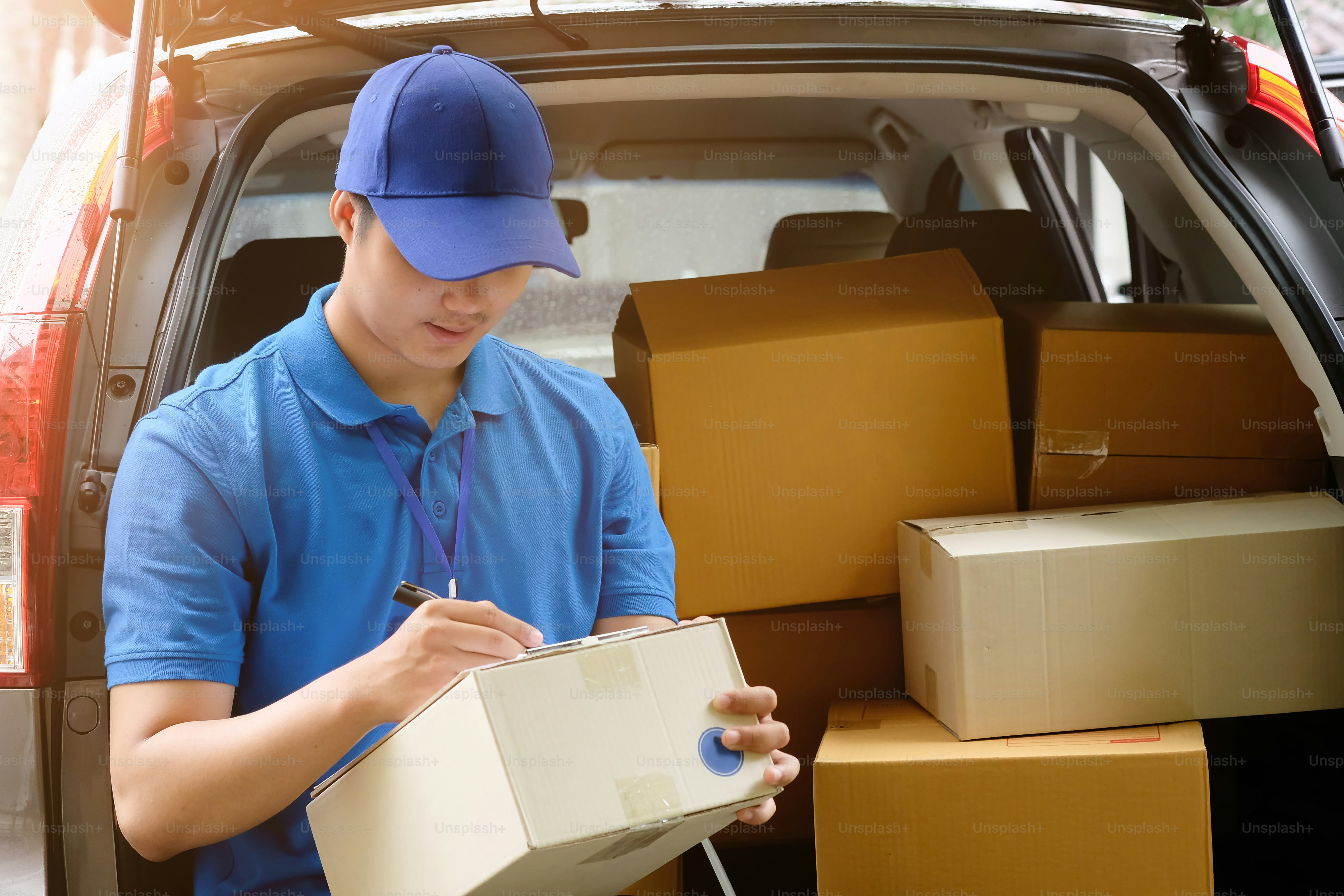 Delivery man working with box on tail truck car. photo – Package ...
