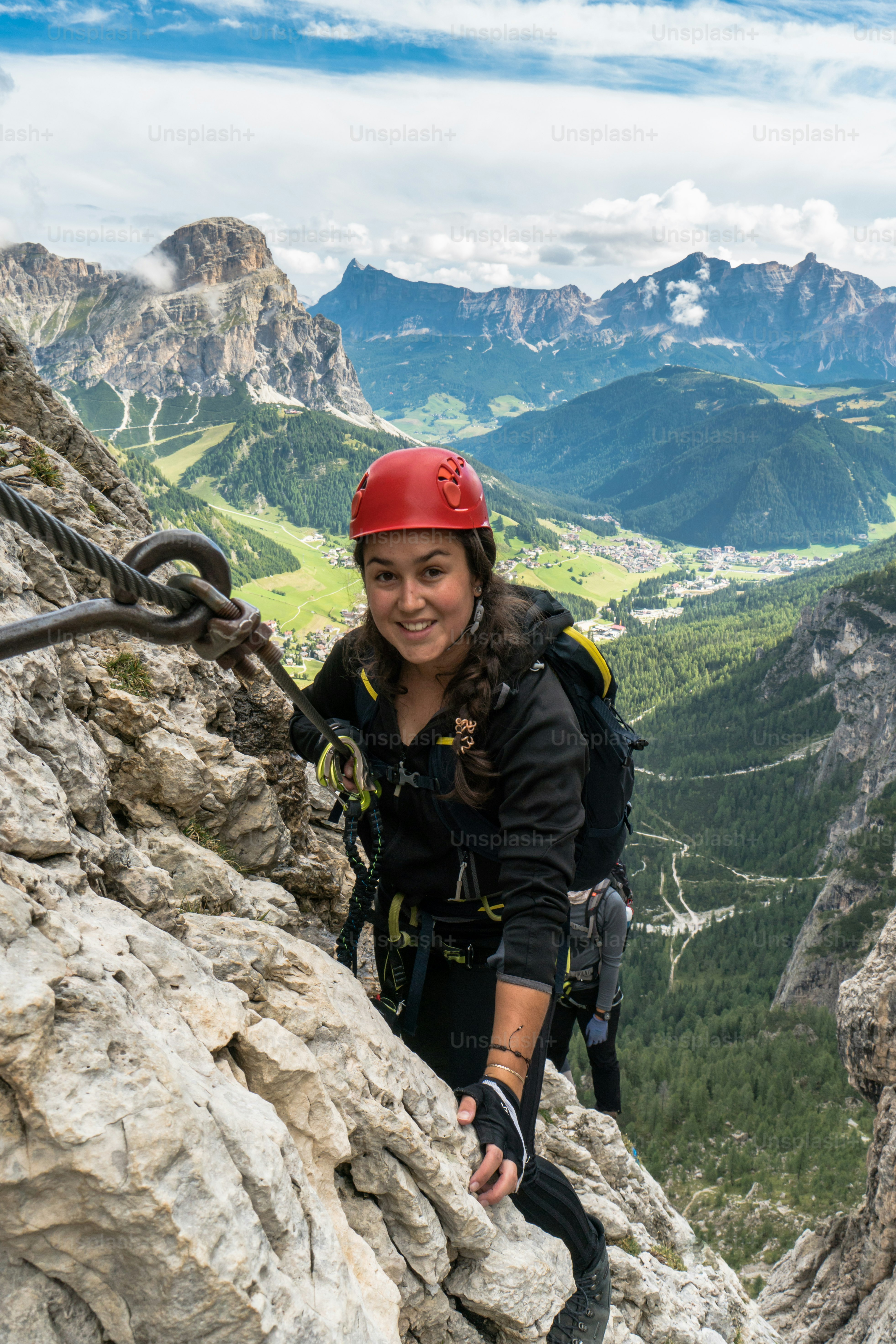 Young attractive female mountain climber on a difficult Via Ferrata in ...