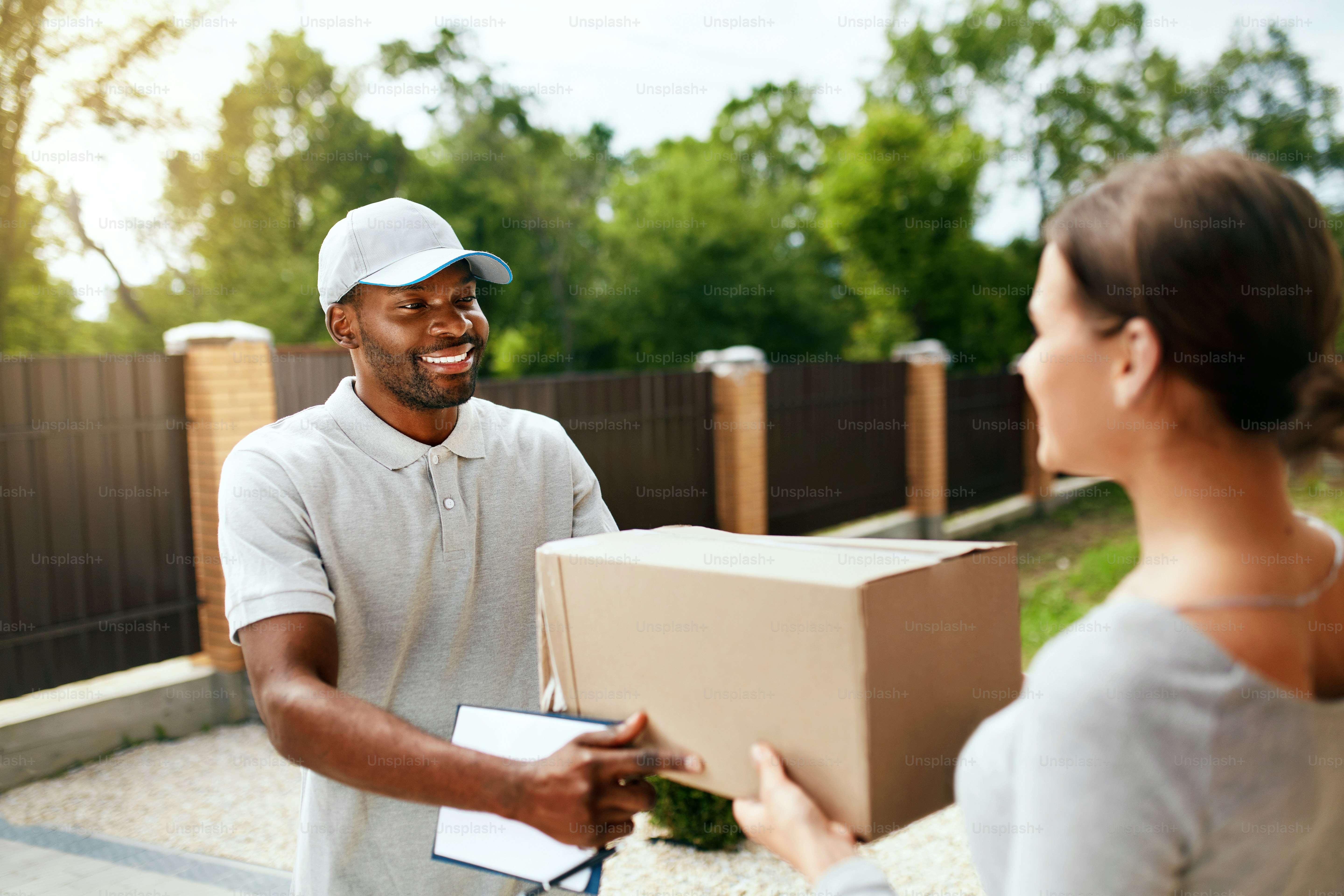 Package Delivering. Delivery Man Delivering Box To Woman Outdoors ...