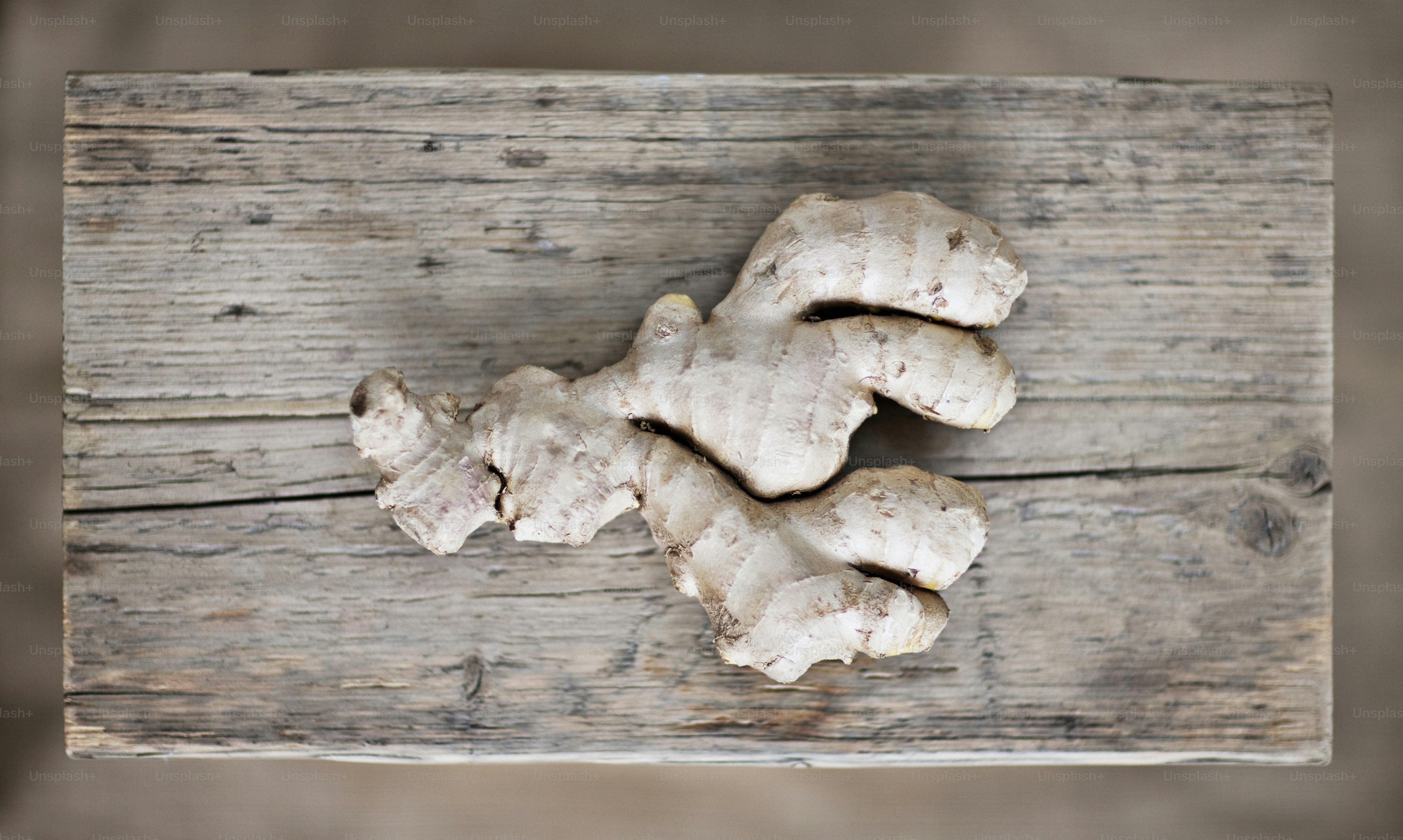A close up of a bunch of ginger on a wooden surface photo – Ginger ...