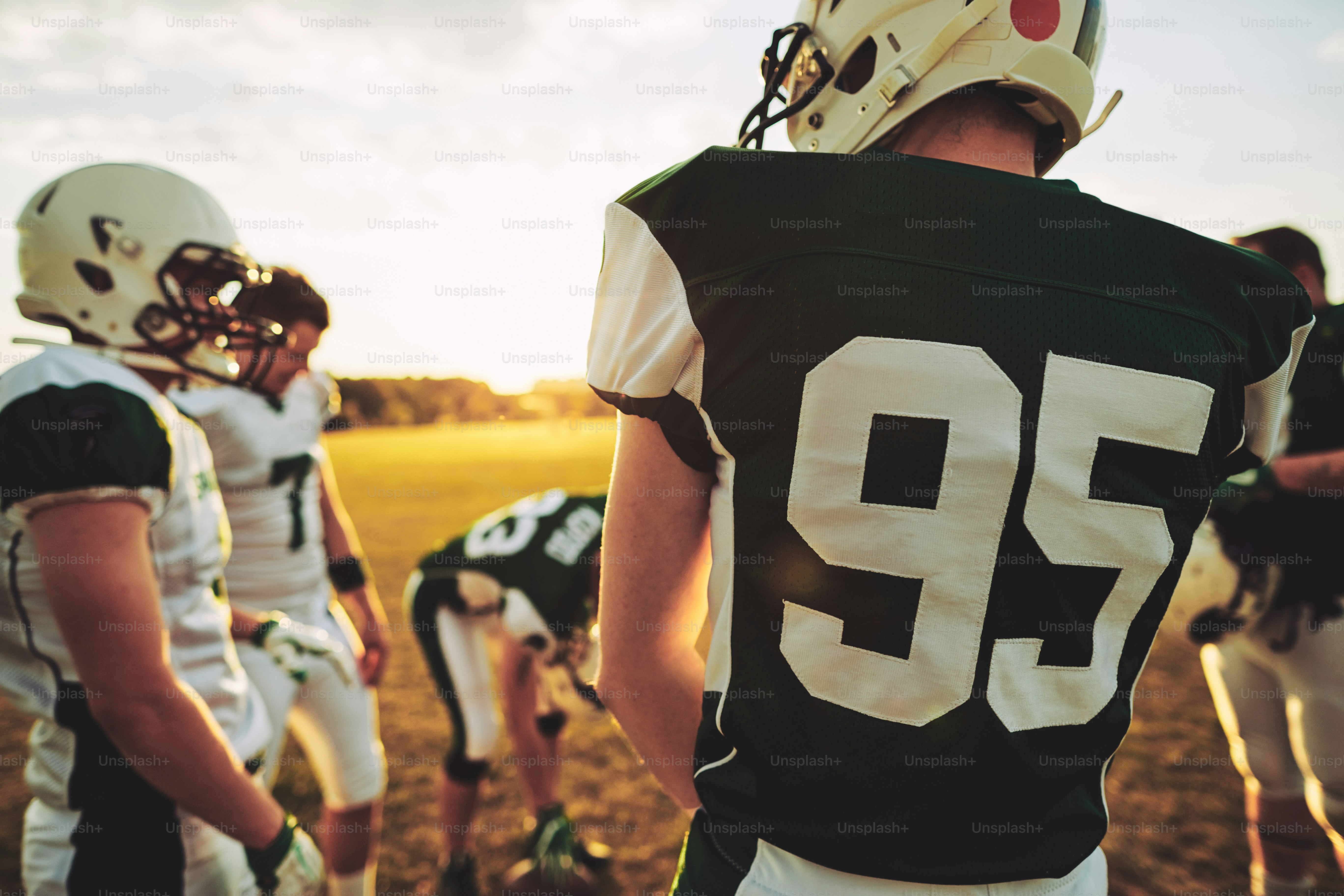 Group of young American football players standing on a sports field ...