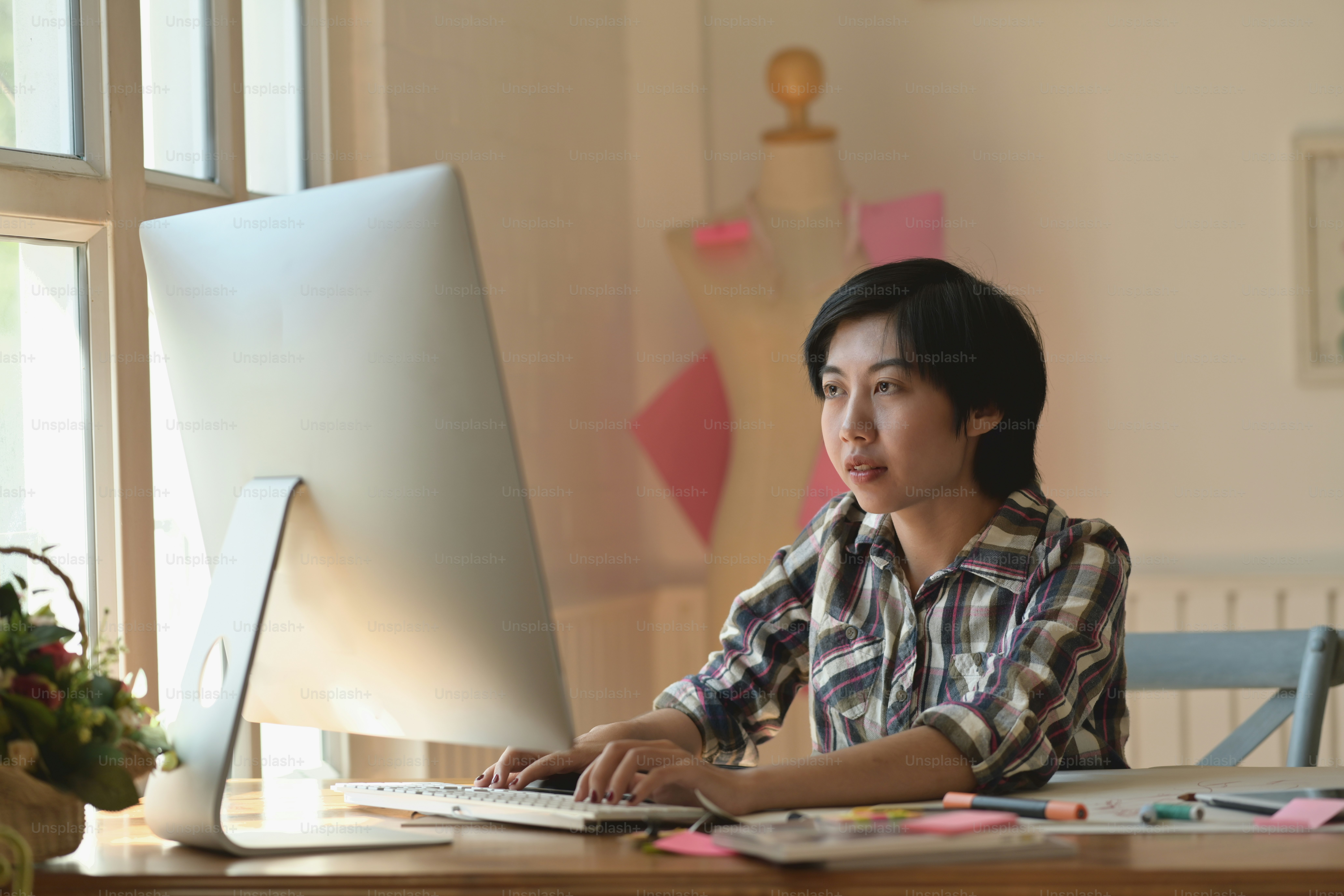 Stylish Asian fashion designer working with modern desktop computer in ...