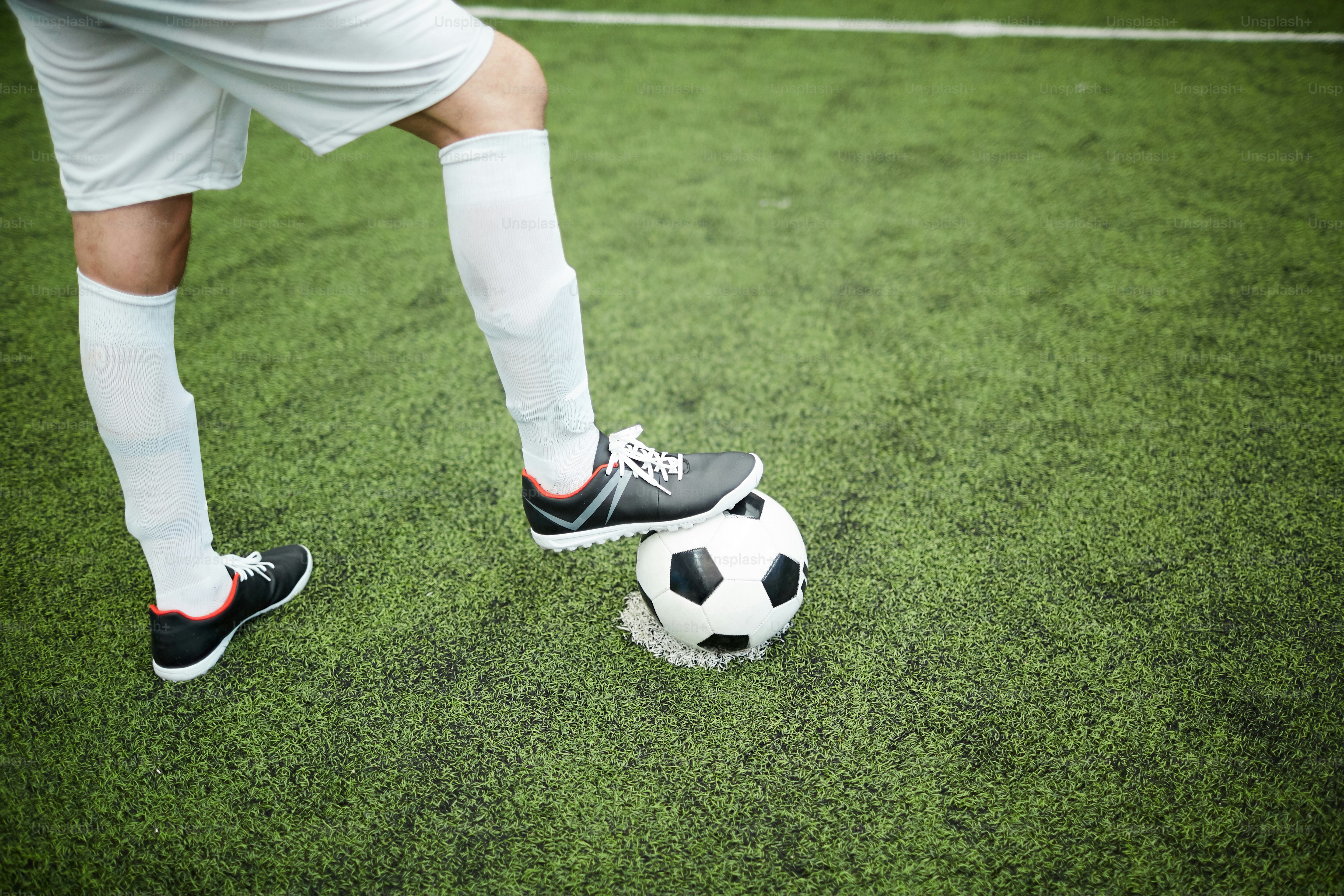Young soccer player standing on green football field with his right ...