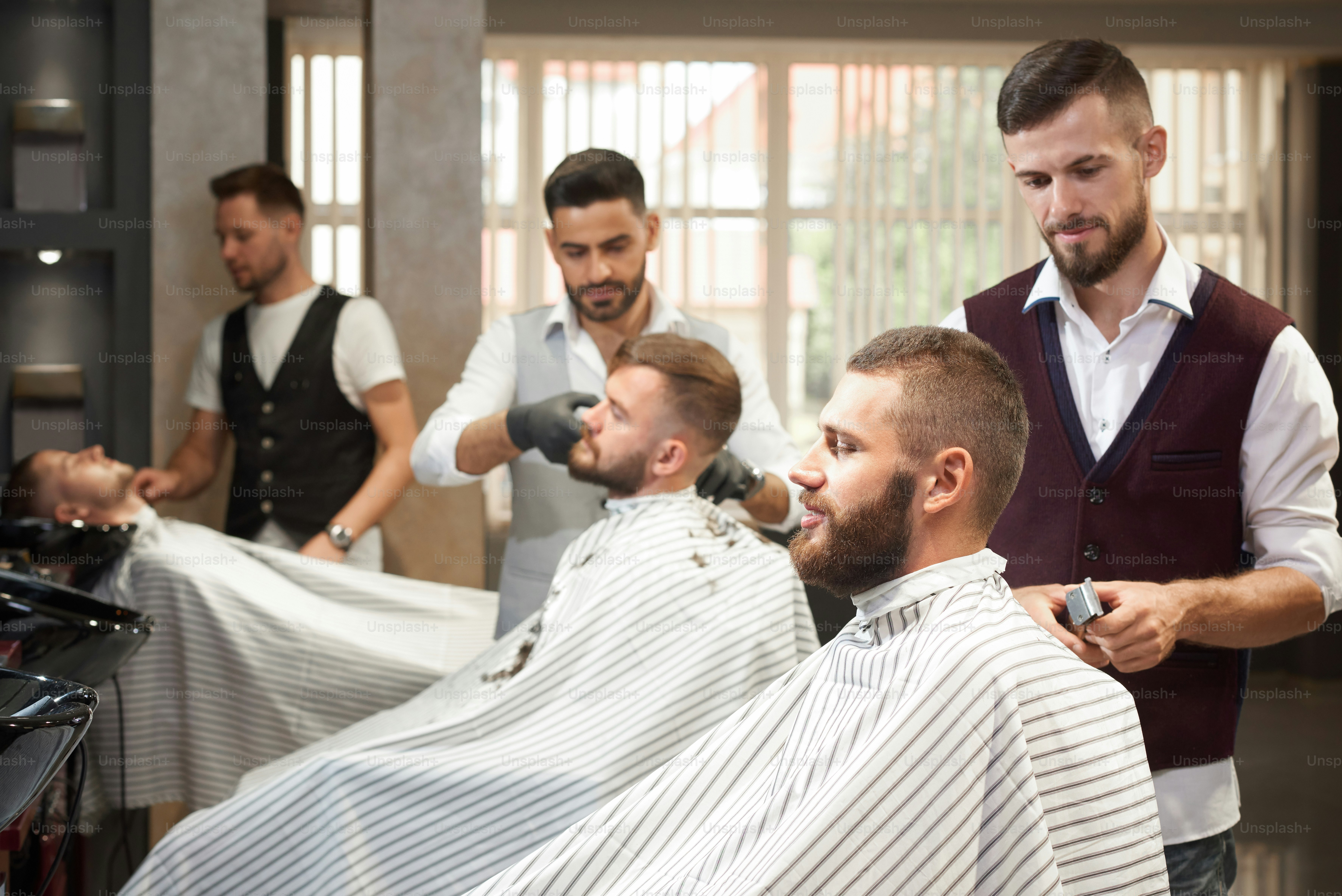 View from side of process of styling hair in vintage barber shop ...