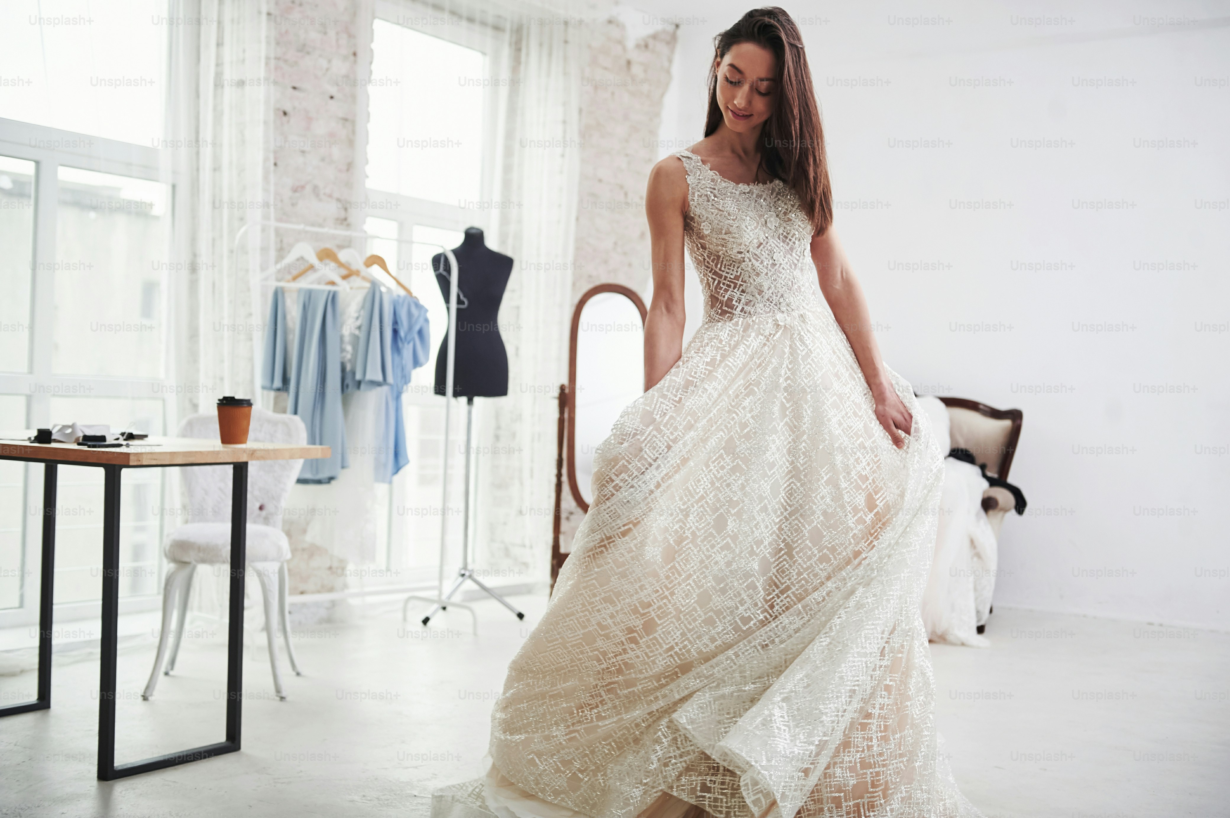 Gorgeous brunette is satisfied. The process of fitting the dress in the ...