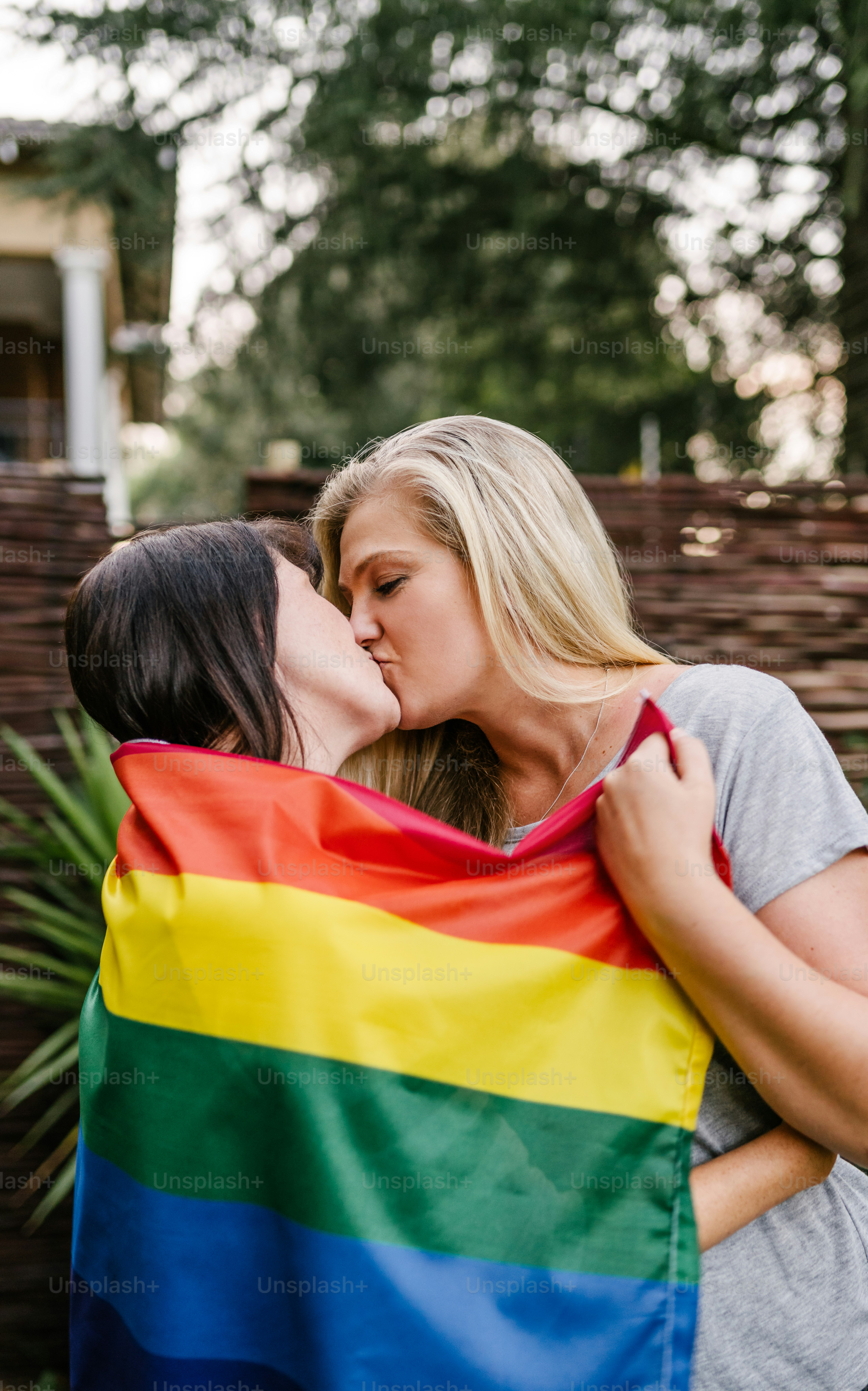 LGBT proud lesbian couple kissing holding gay rainbow flag photo ...