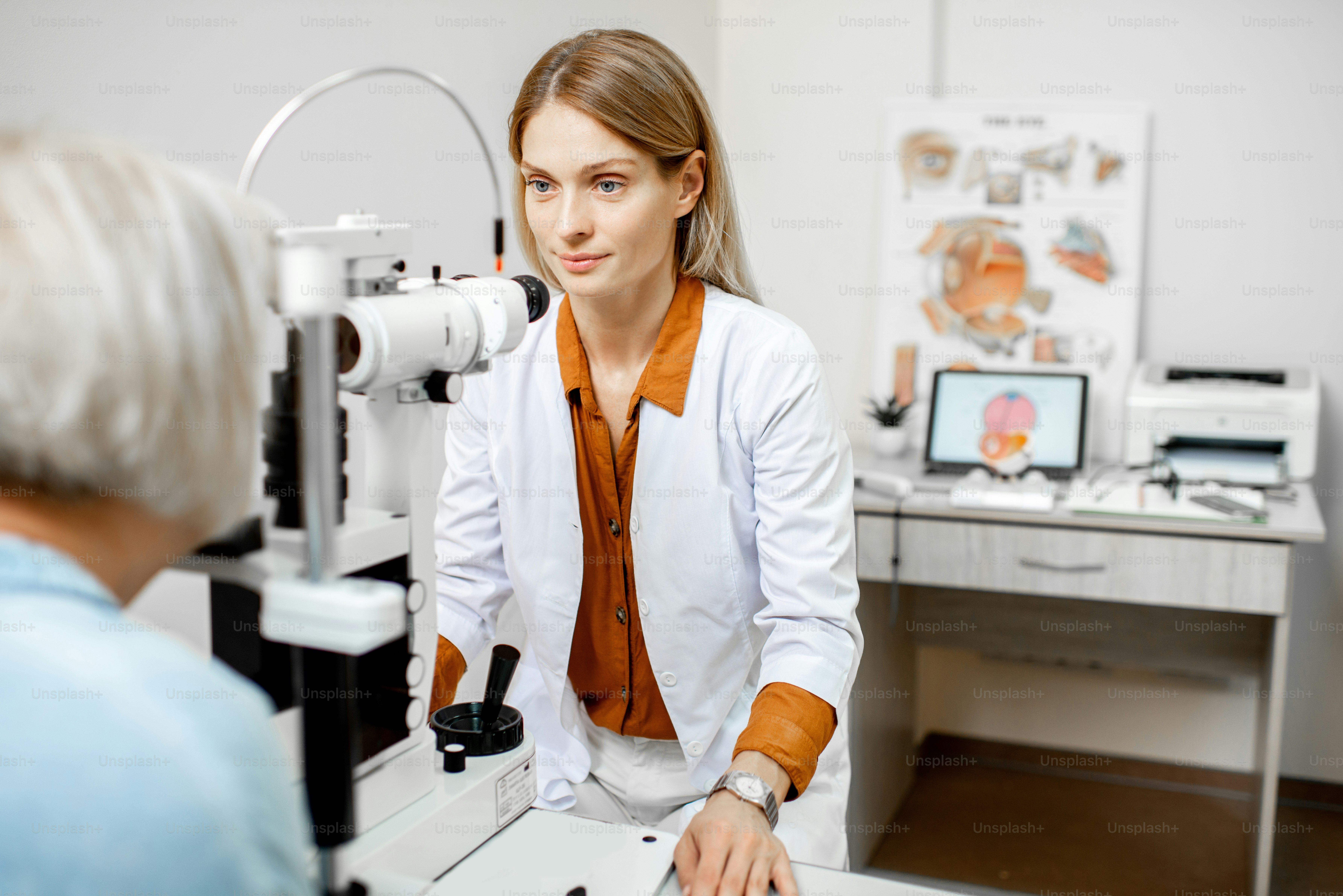 Ophthalmologist examining eyes of a senior patient using microscope ...