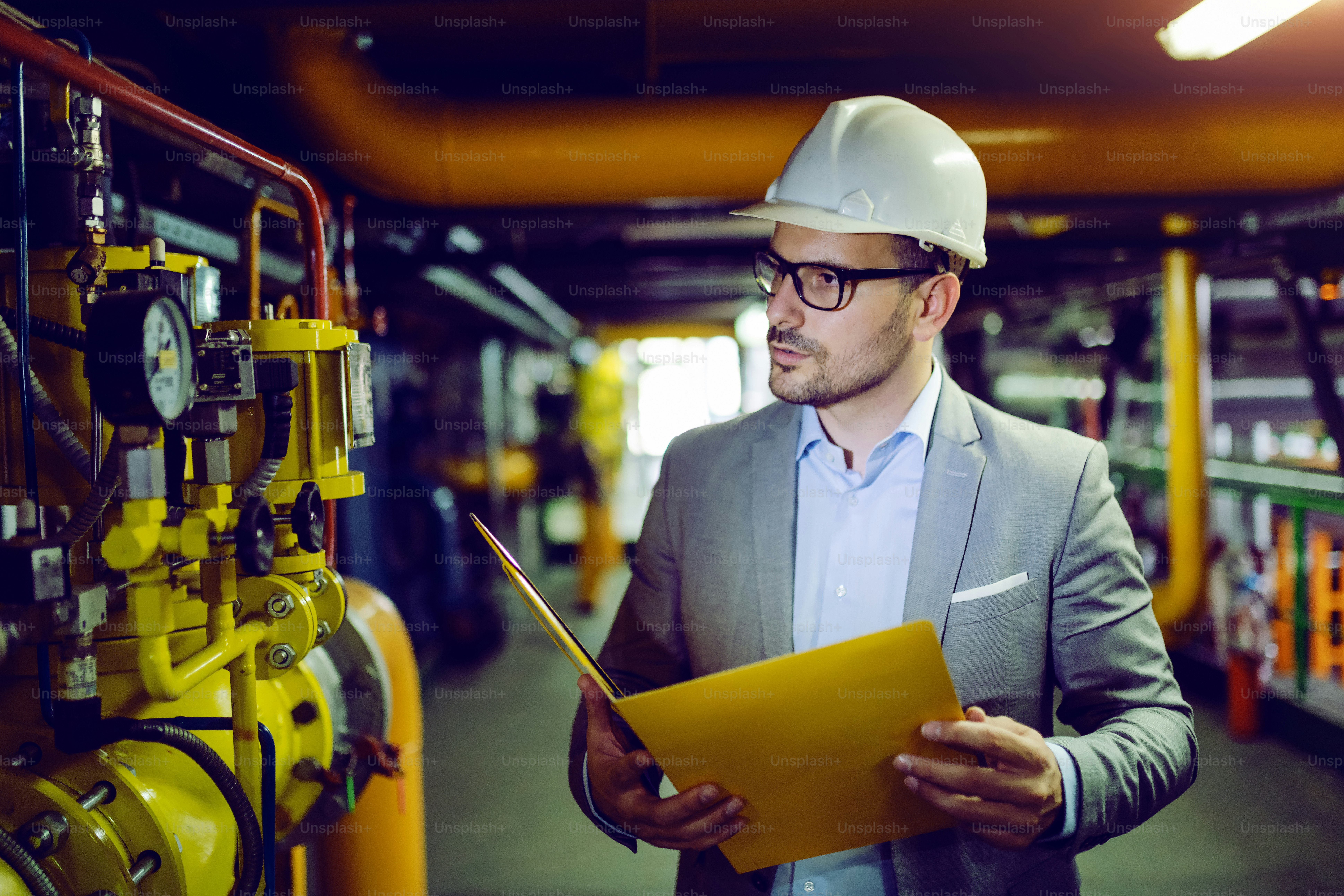 Foto Supervisor caucásico serio con traje y casco en la cabeza ...