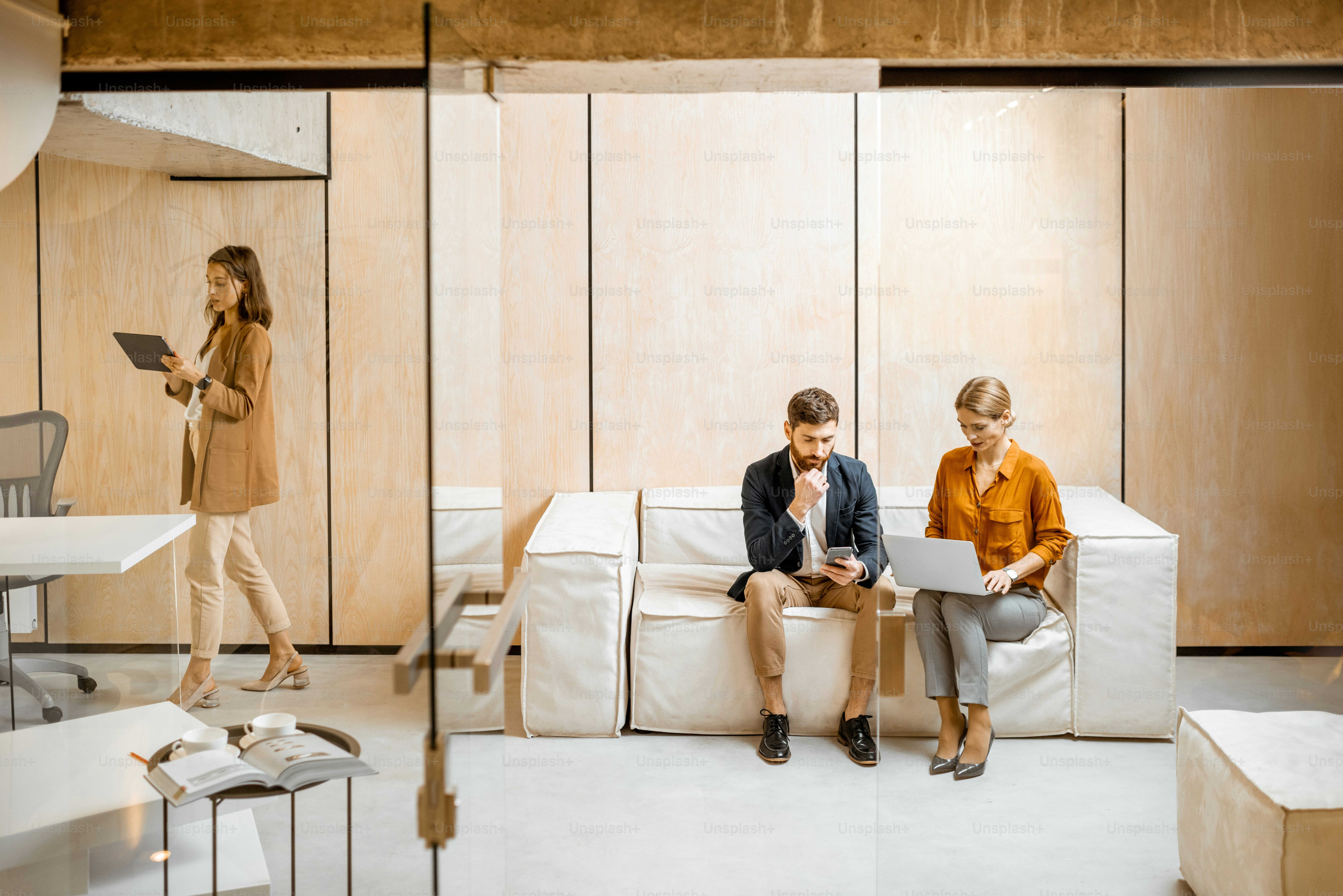 Creative colleagues working on laptop and digital tablet, sitting on ...