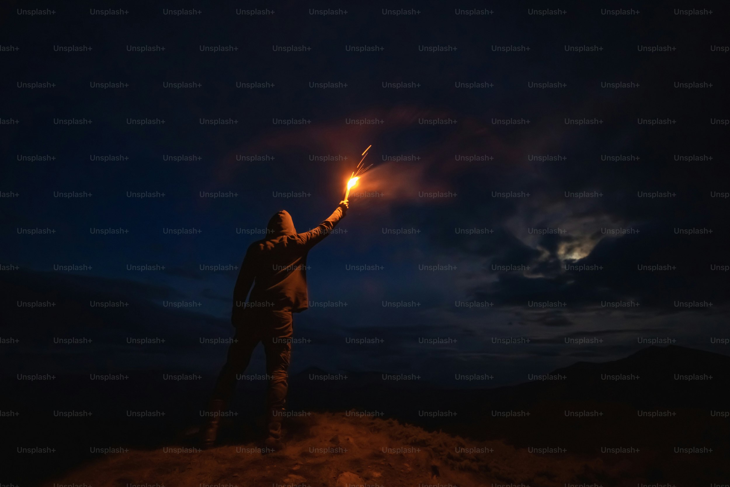 The male with a firework stick standing on the night mountain photo ...