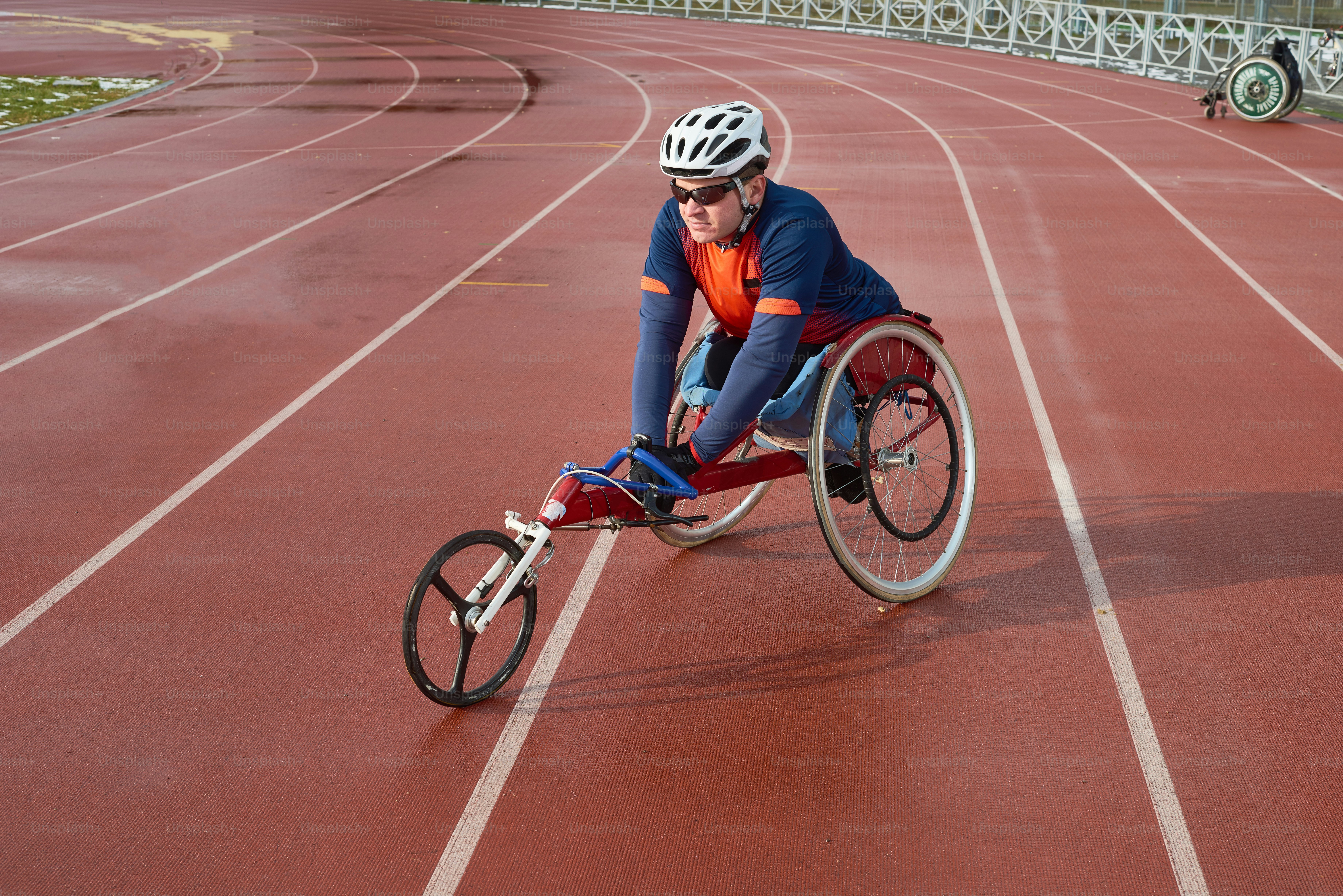 Handicapped sportsman in helmet and sunglasses sitting in racing ...