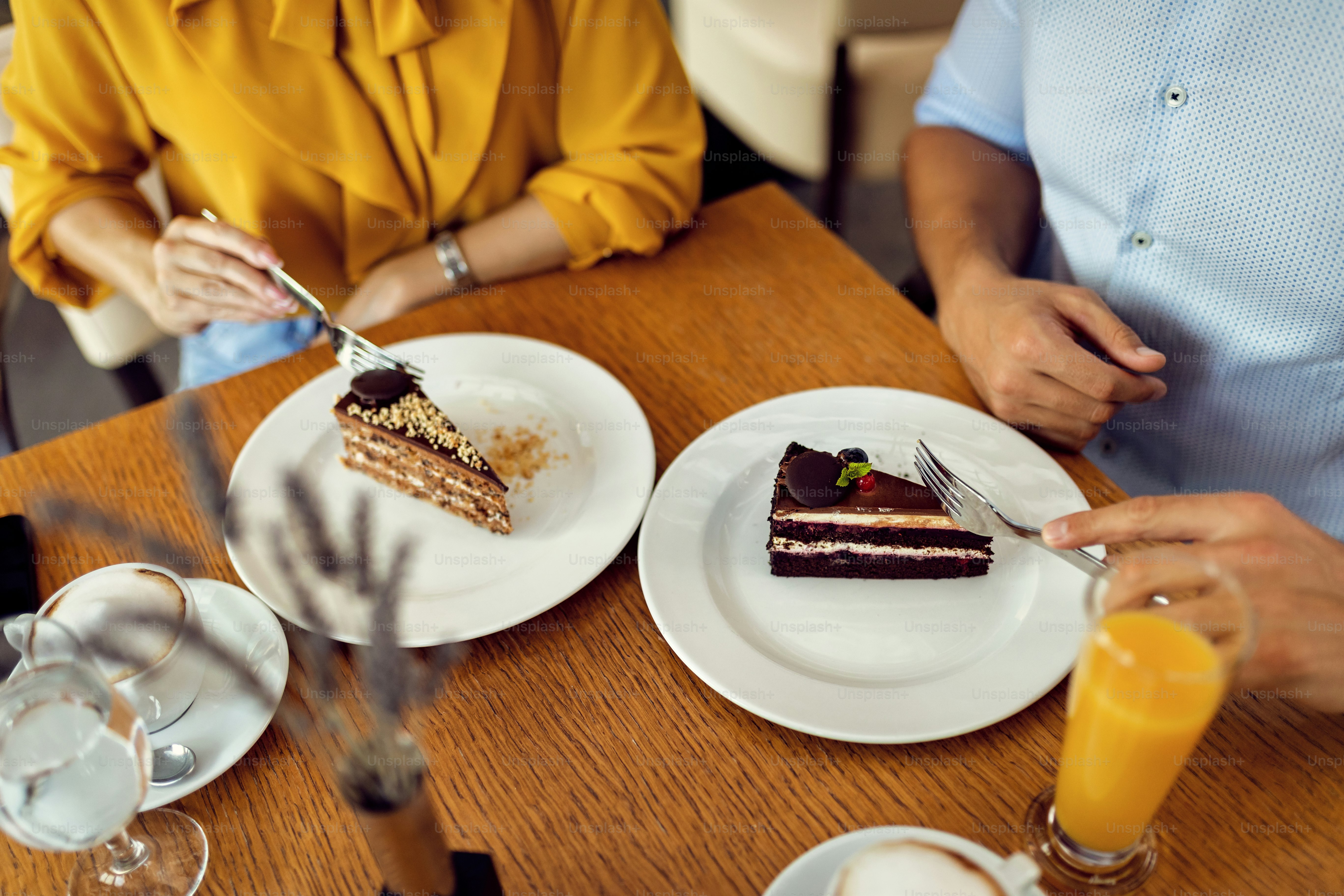 Close-up of a couple eating cake for dessert in a cafe. photo ...