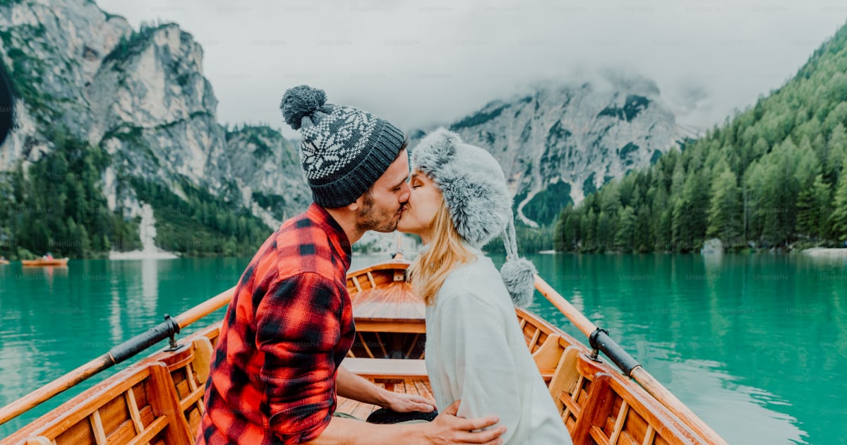 イタリアのブレイズの高山湖を訪れる大人のカップルのロマンチックなキス。秋の山で一緒に愛する瞬間を過ごす恋の観光客。カップル、放浪癖、旅行の