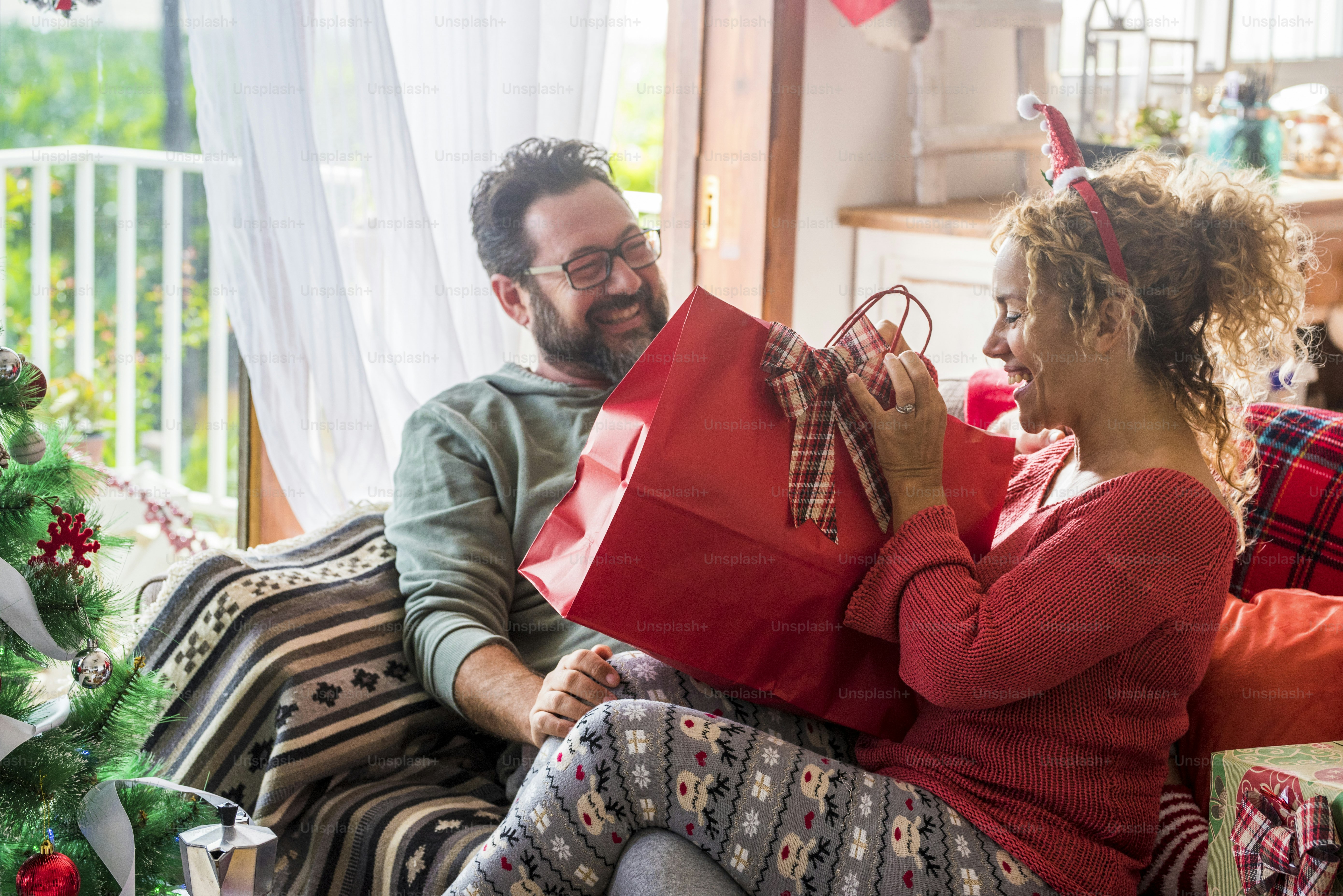 Happy couple at home enjoy Christmas eve together sharing gift smiling ...
