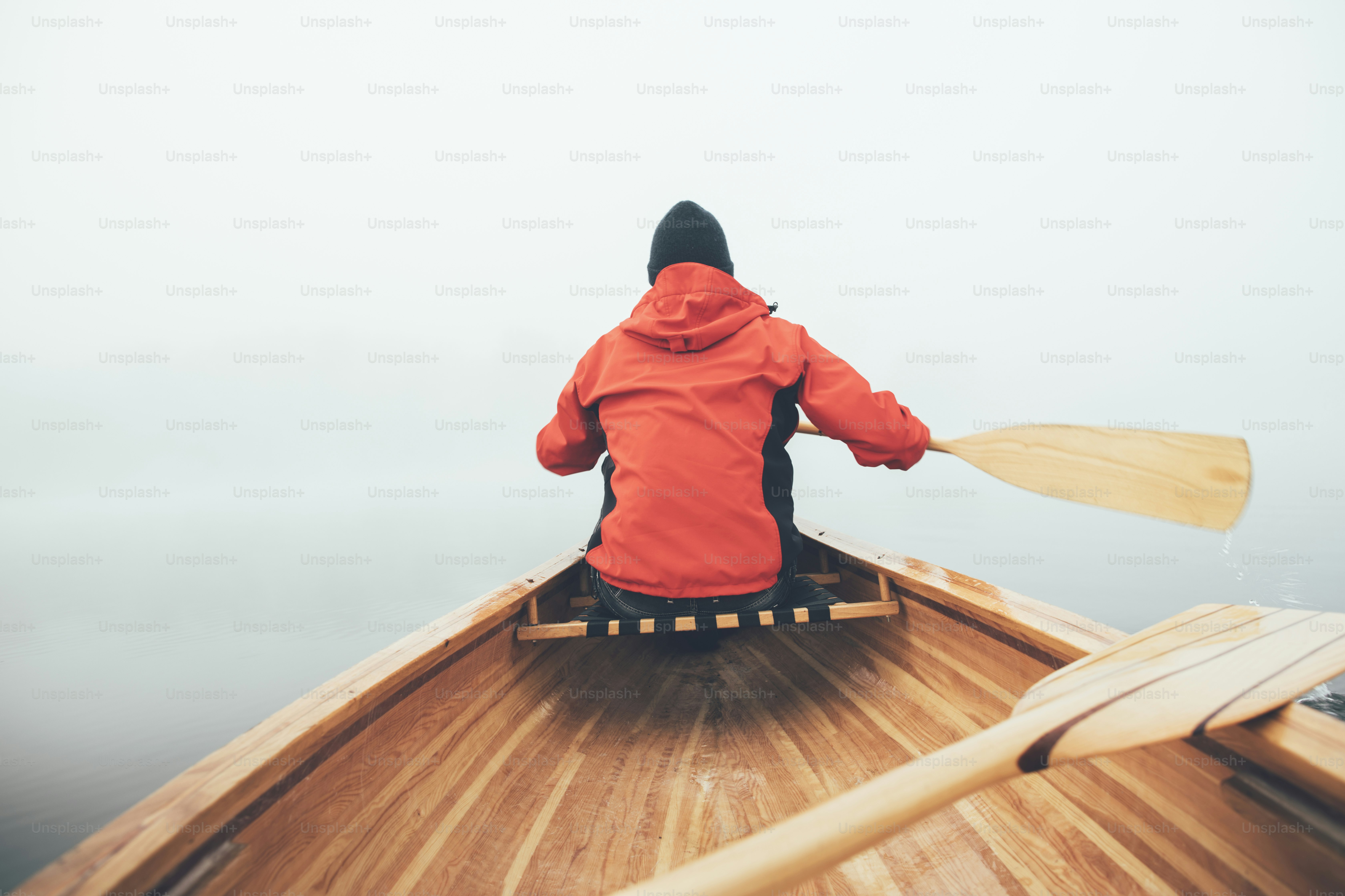 Rear view of man paddling canoe in the winter. photo – Copy space Image ...