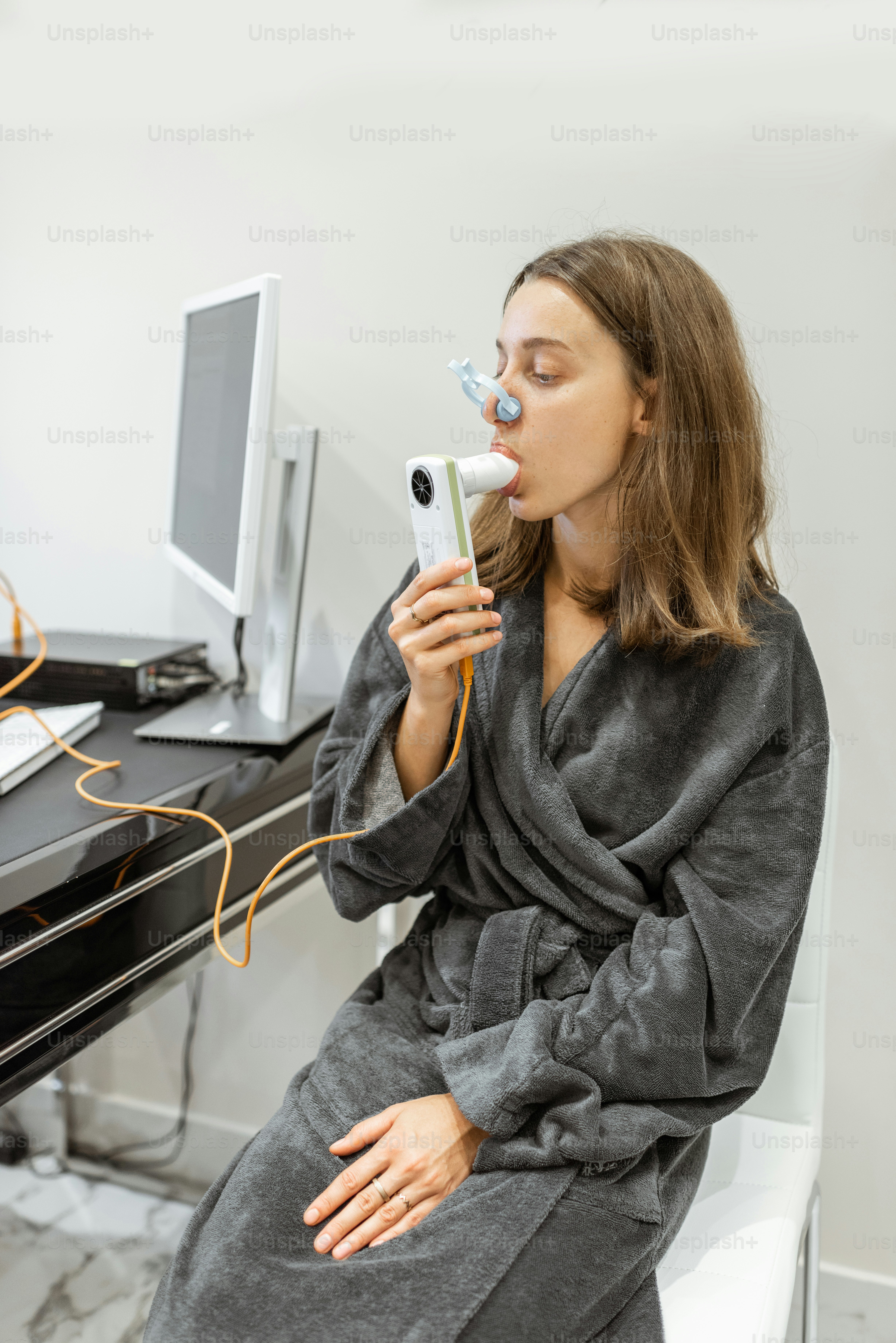 Young woman during a spirography test, measuring breathing movements ...