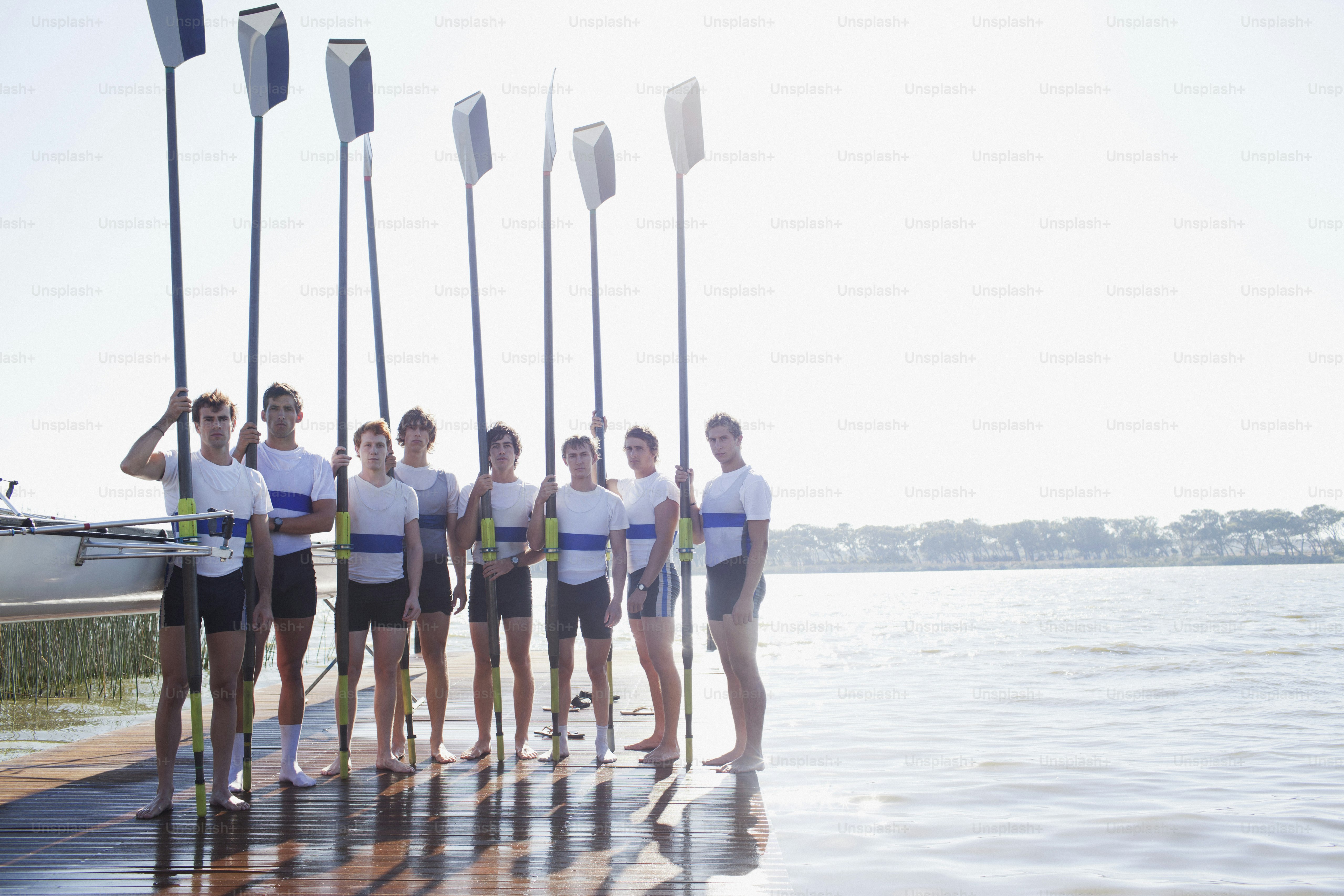 A group of people rowing a long boat in the water photo – Teamwork ...