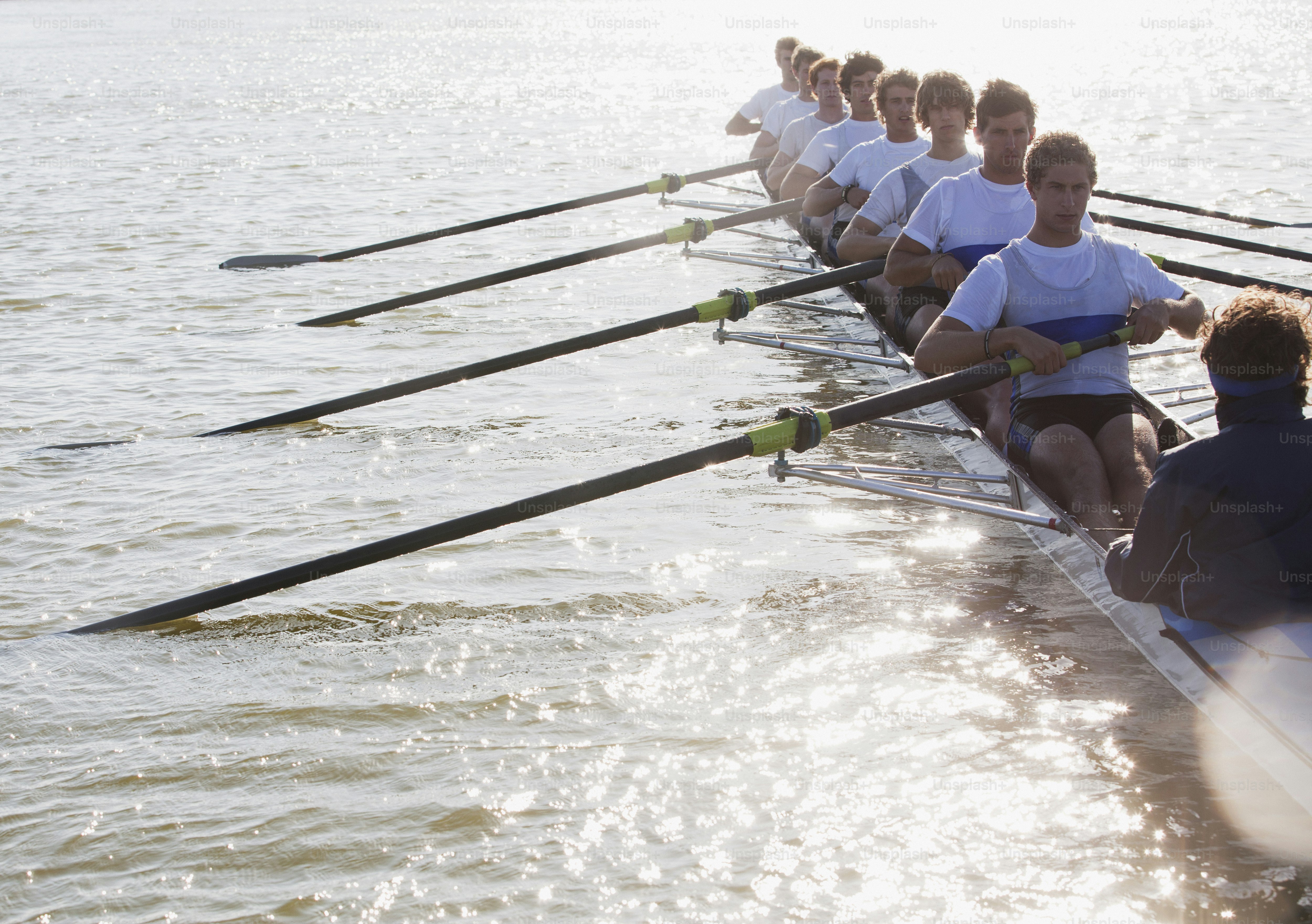 A row of rowers sitting on the side of a boat photo – Rowing Image on ...