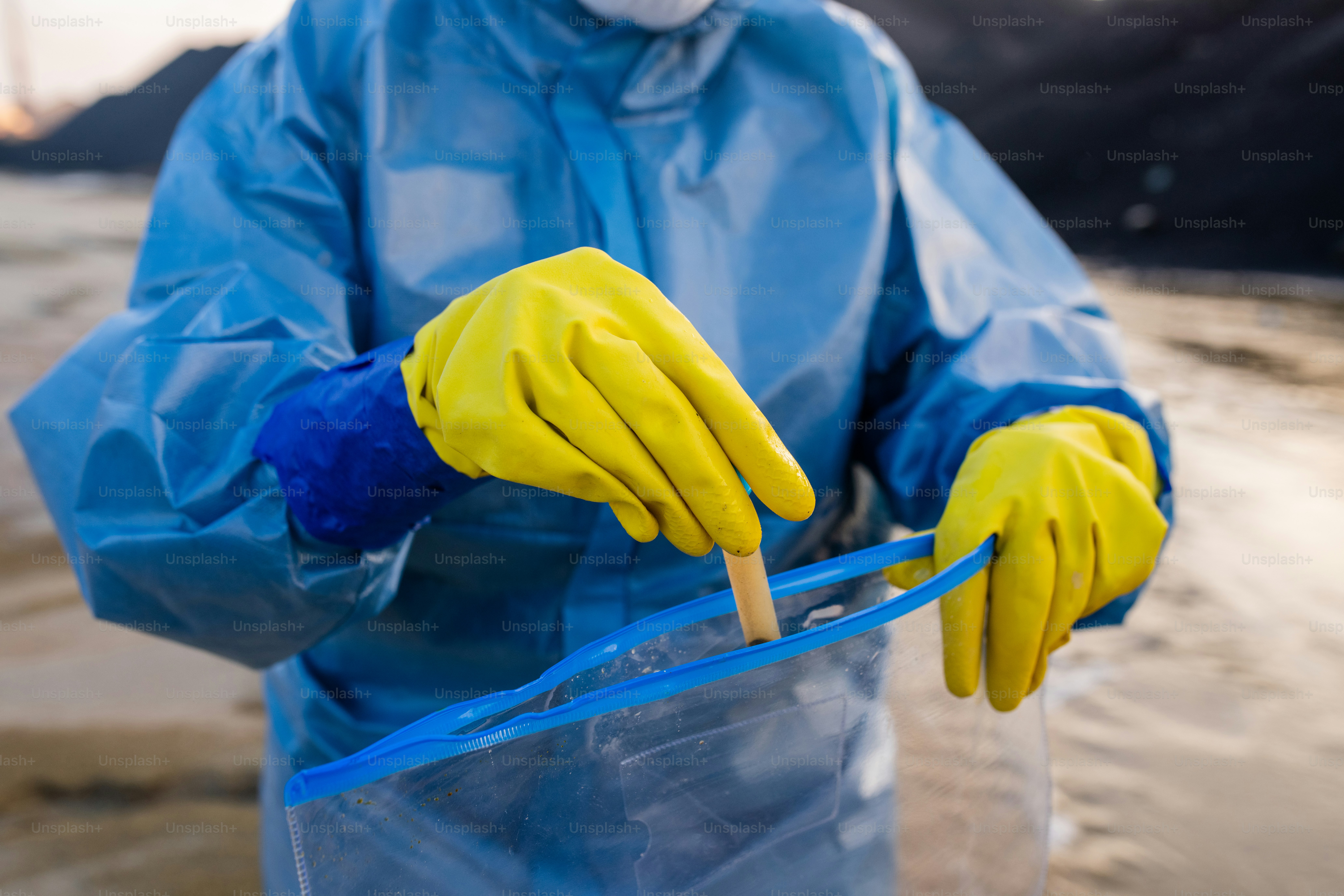 Gloved hands of contemporary researcher or ecologist in protective ...