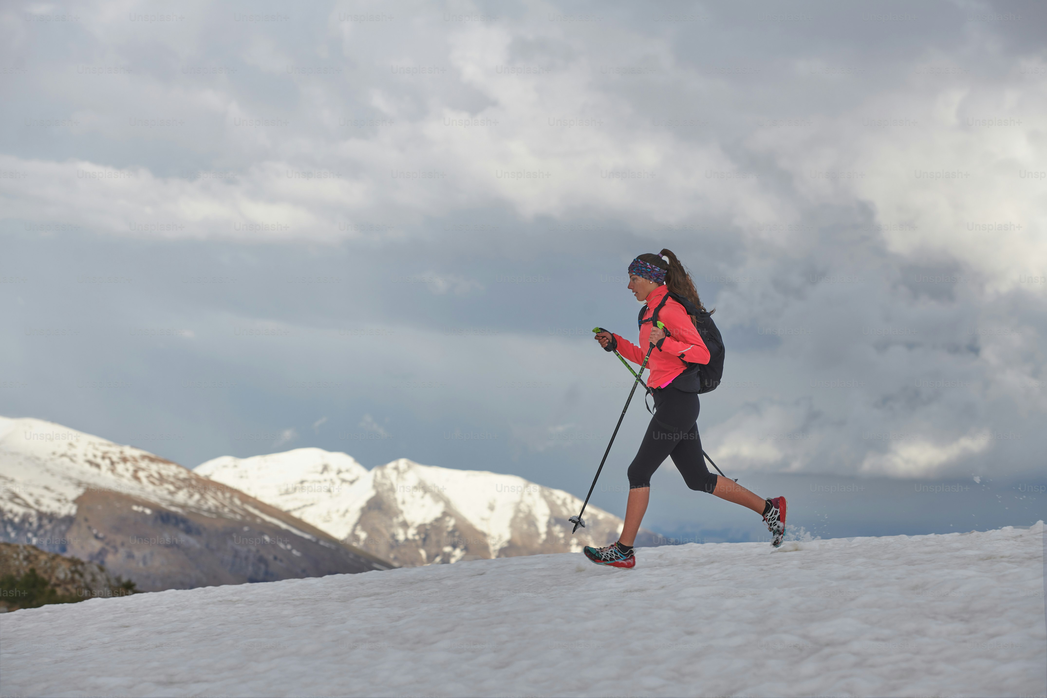 Foto zum Thema Athletin läuft zum Skyrunning-Training auf den Schnee ...