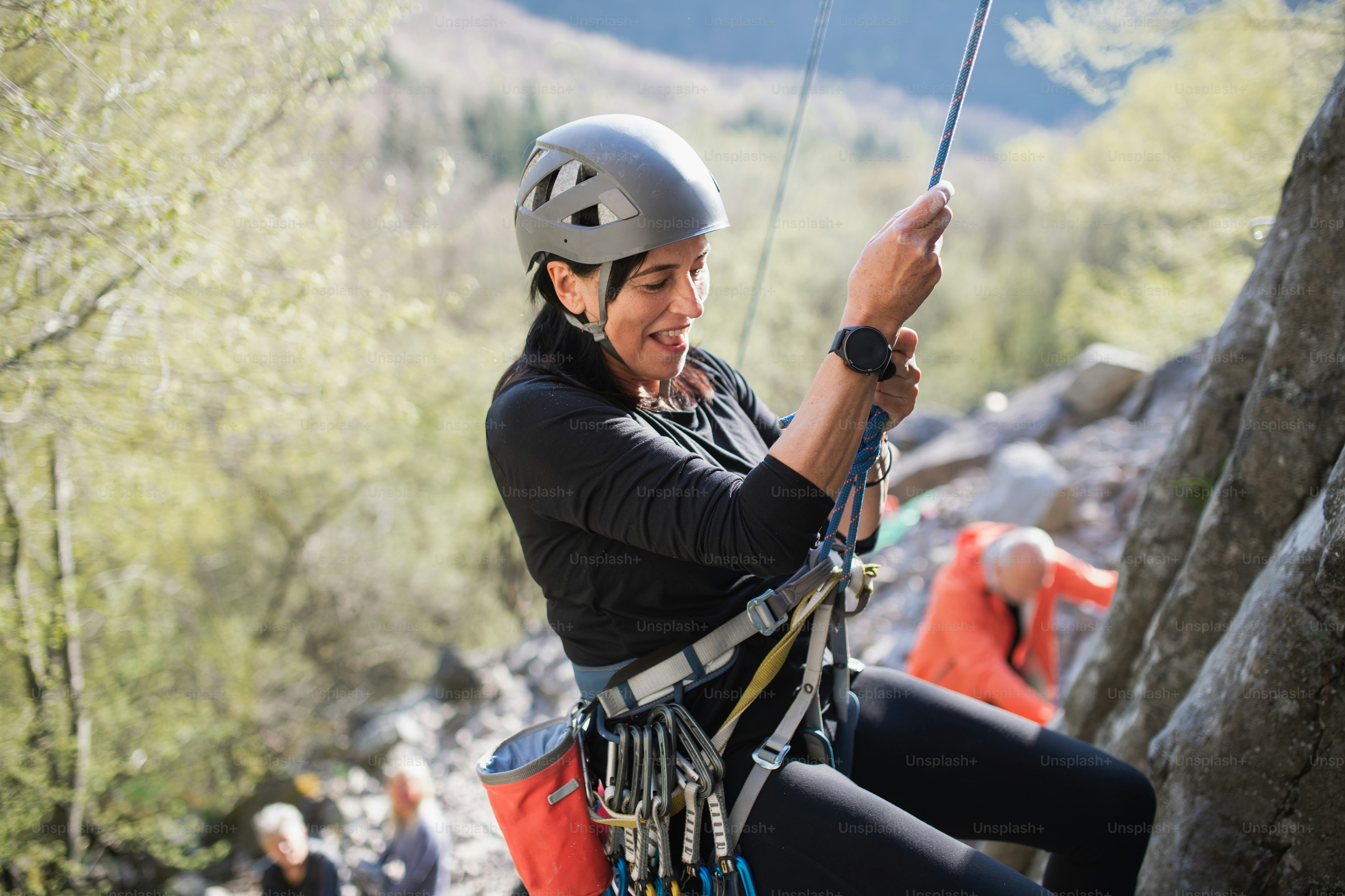 Portrait of senior woman climbing rocks outdoors in nature, active ...