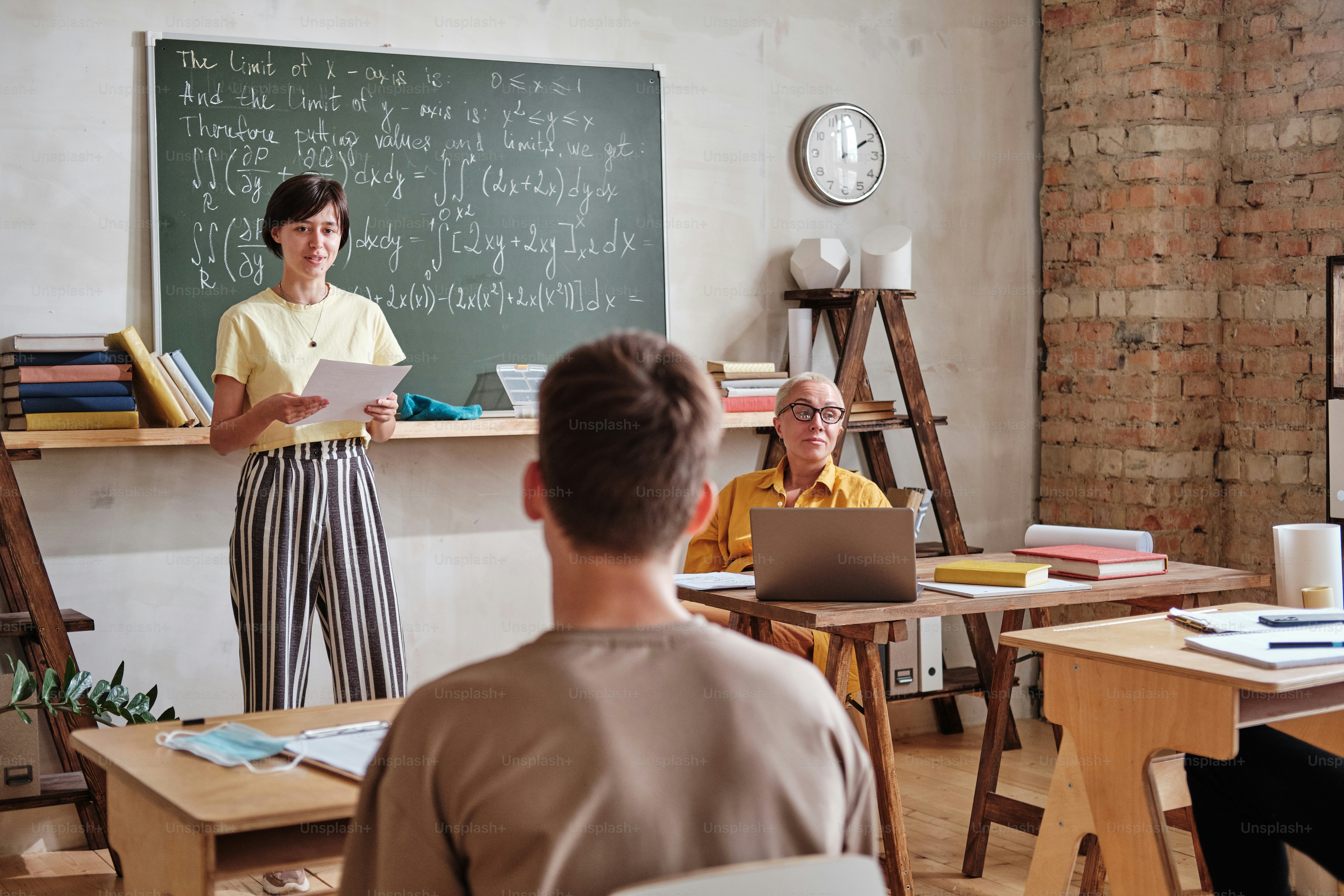 Student presenting her report to teacher and her classmates during ...