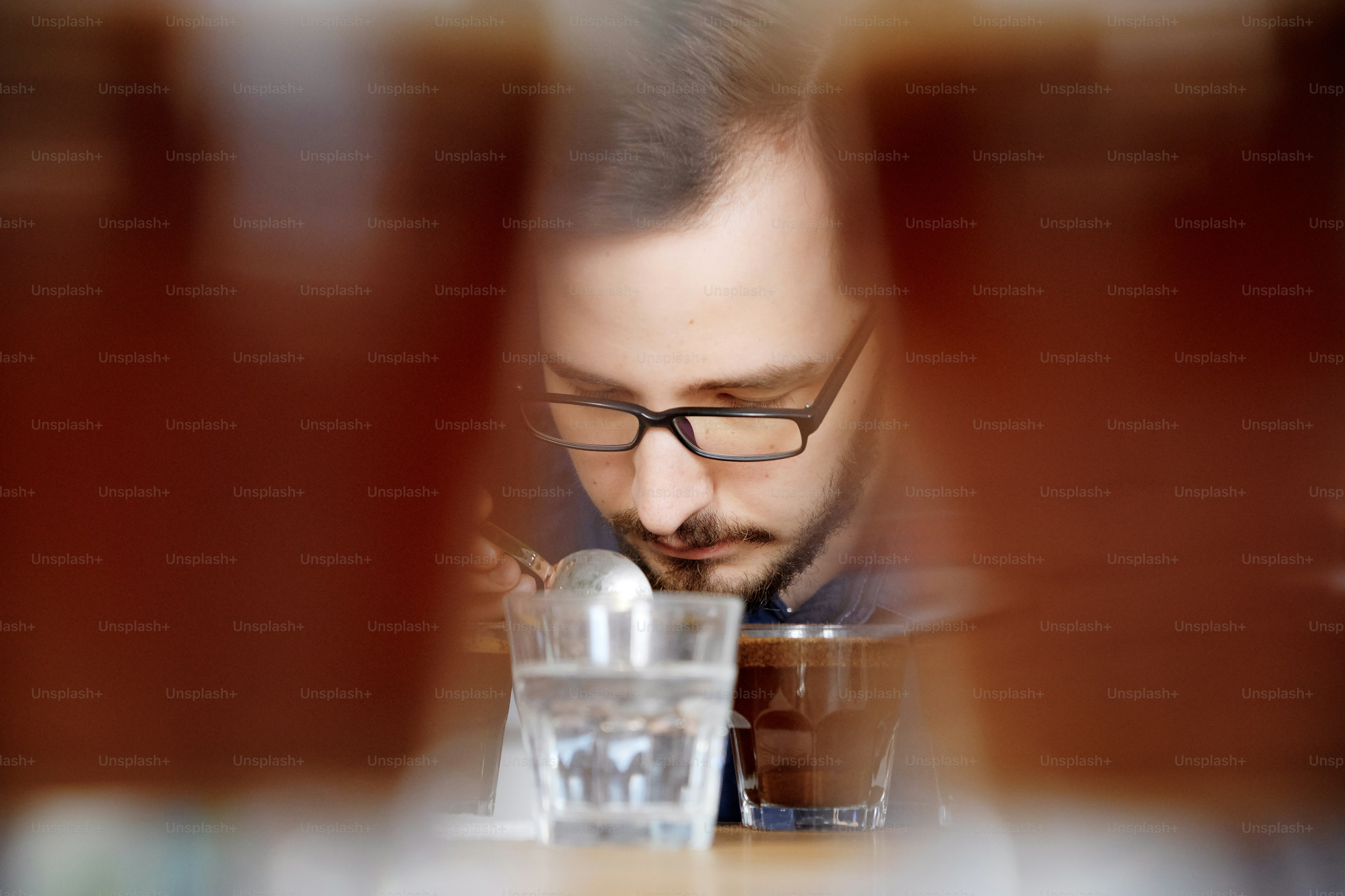 Portrait of man smelling freshly brewed coffee in glass cup, using ...