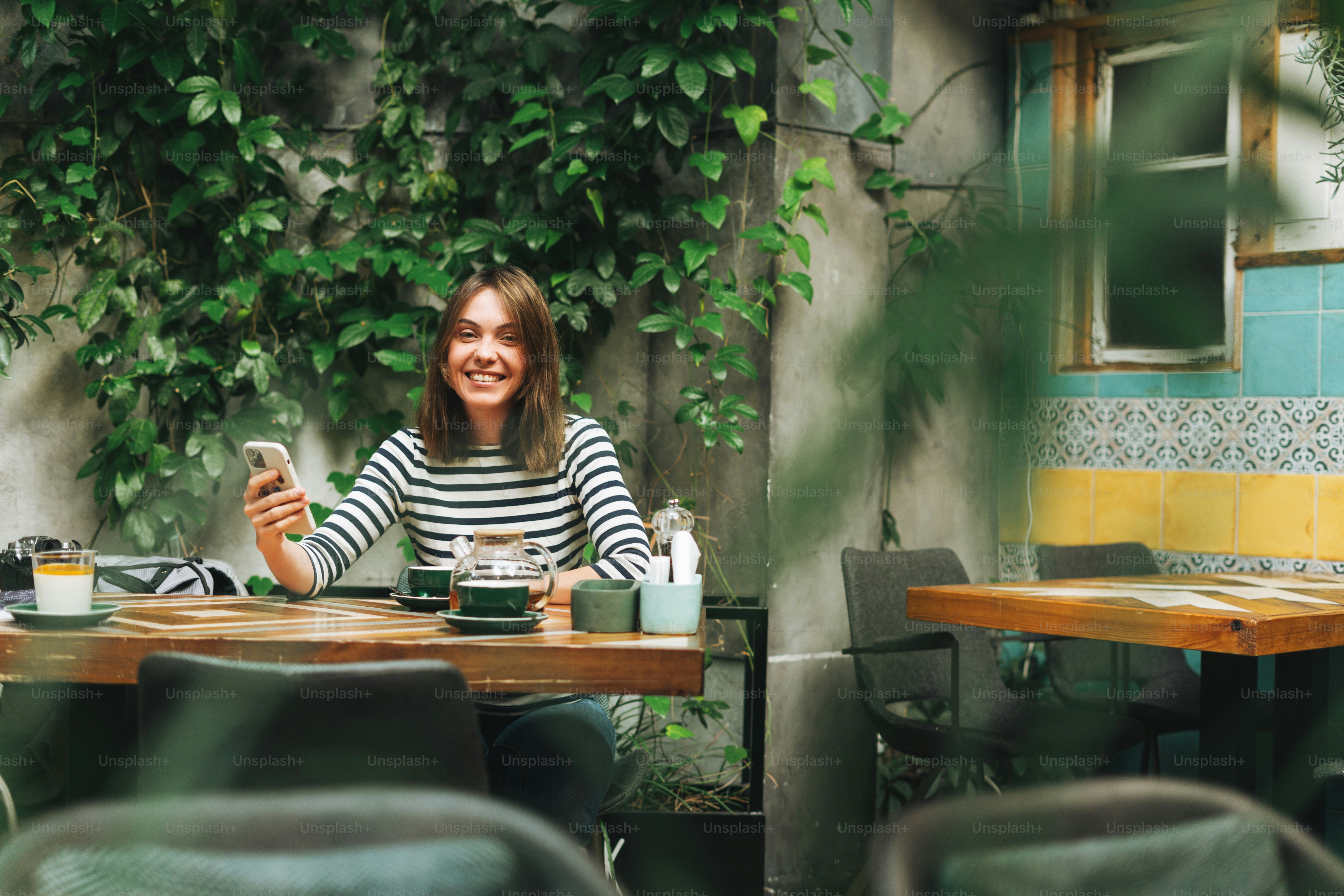 Young smiling brunette woman in casual clothes using social media on ...