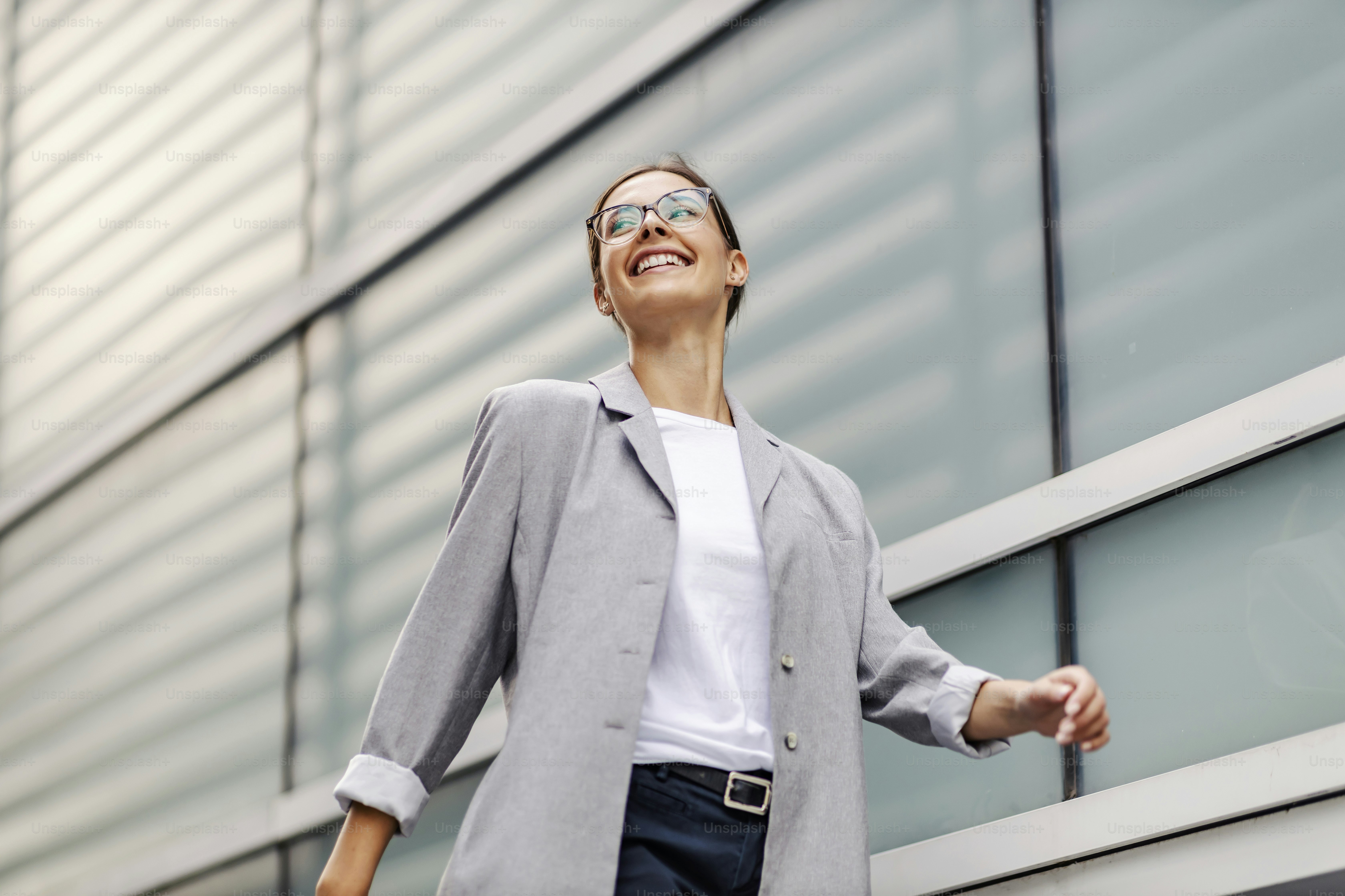 Low angle view of young, smiling businesswoman dressed elegantly ...