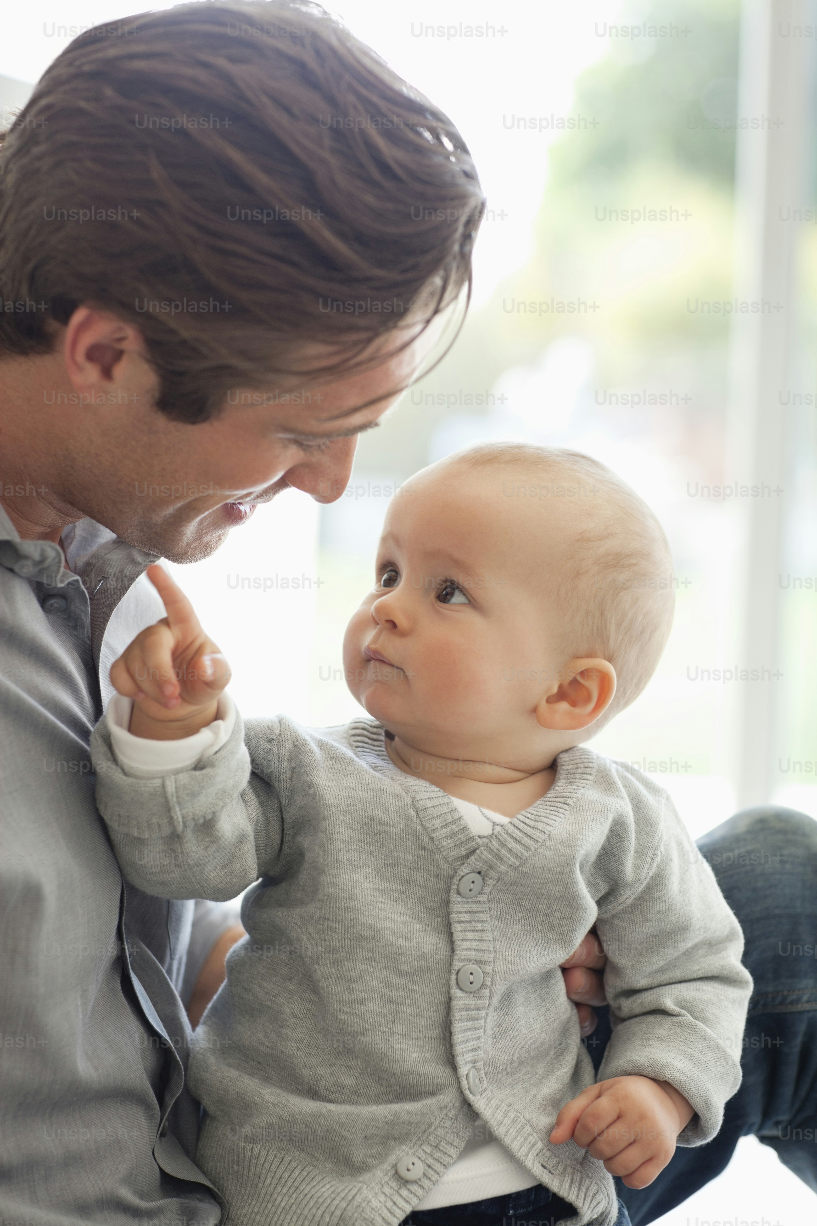 Foto Un hombre sosteniendo a un bebé en su regazo – Unión Imagen en ...