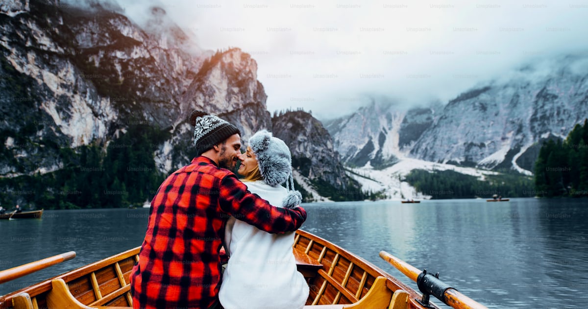イタリアのブレイズの高山湖を訪れるボートのロマンチックなカップル。秋の山で一緒に愛する瞬間を過ごす恋の観光客。旅行、カップル、放浪についての