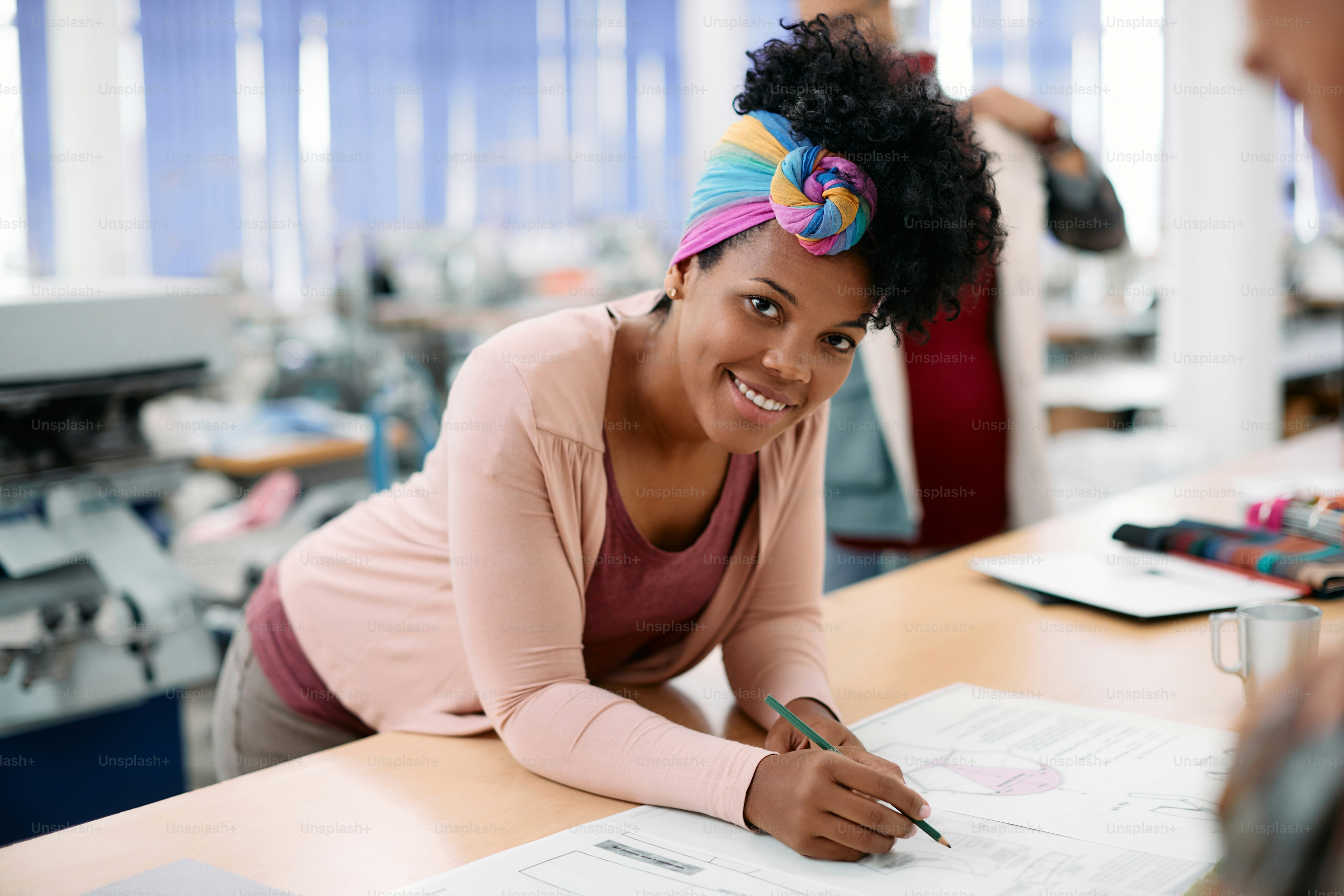Happy African American clothing designer working at her fashion design ...