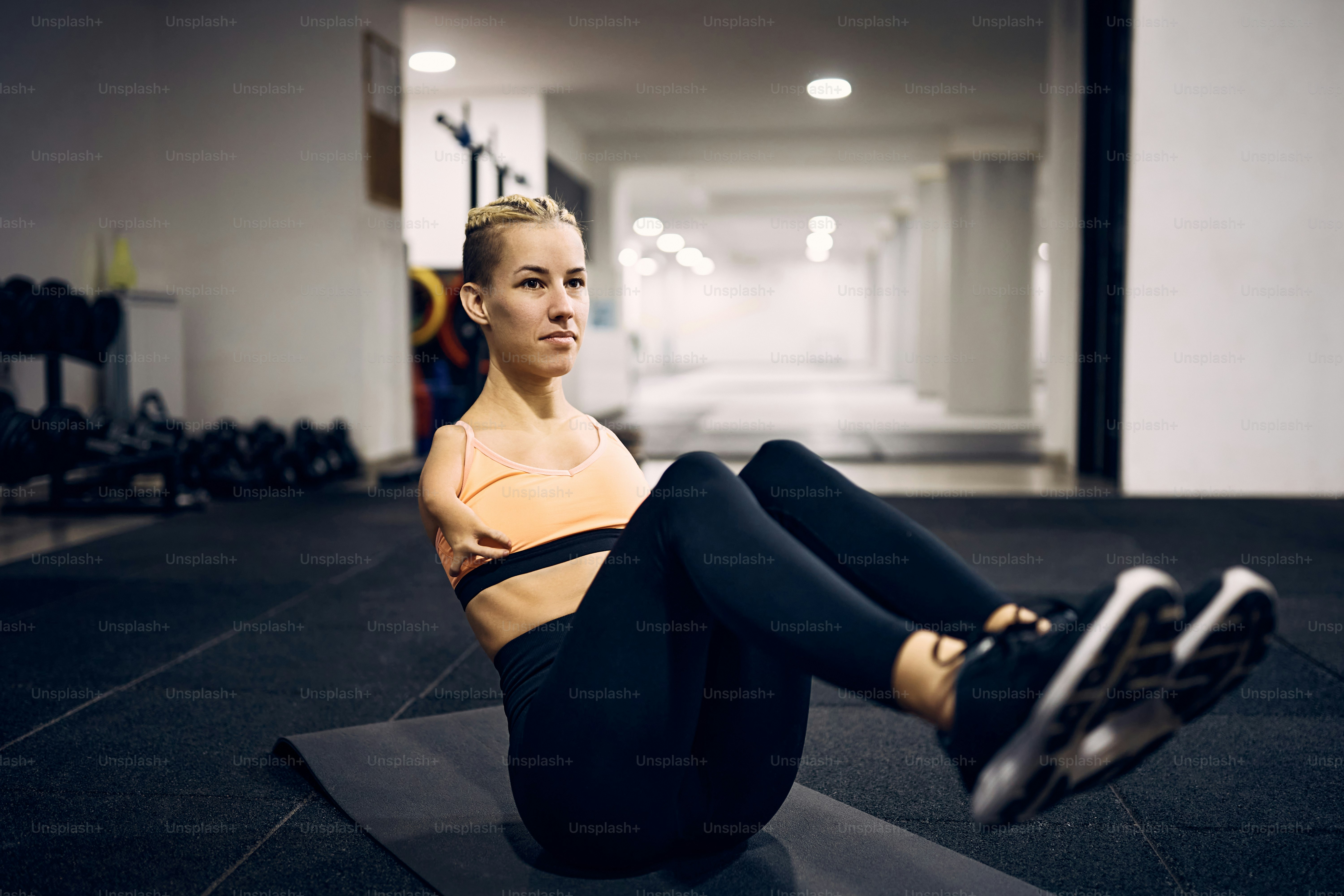 Athletic woman with a disability doing sit-ups while exercising in a ...