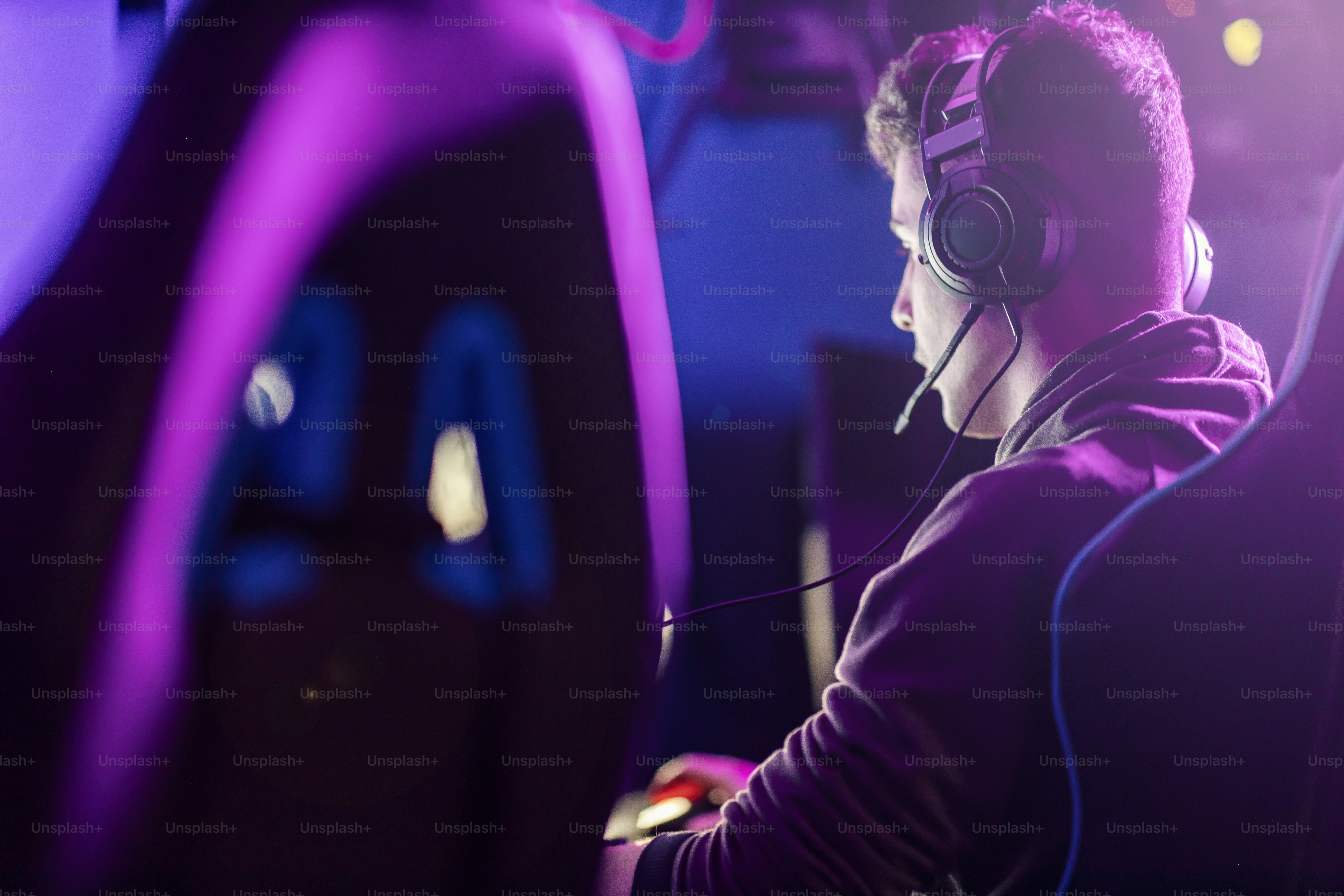 Un joueur concentré jouant à des jeux vidéo sur ordinateur dans une ...