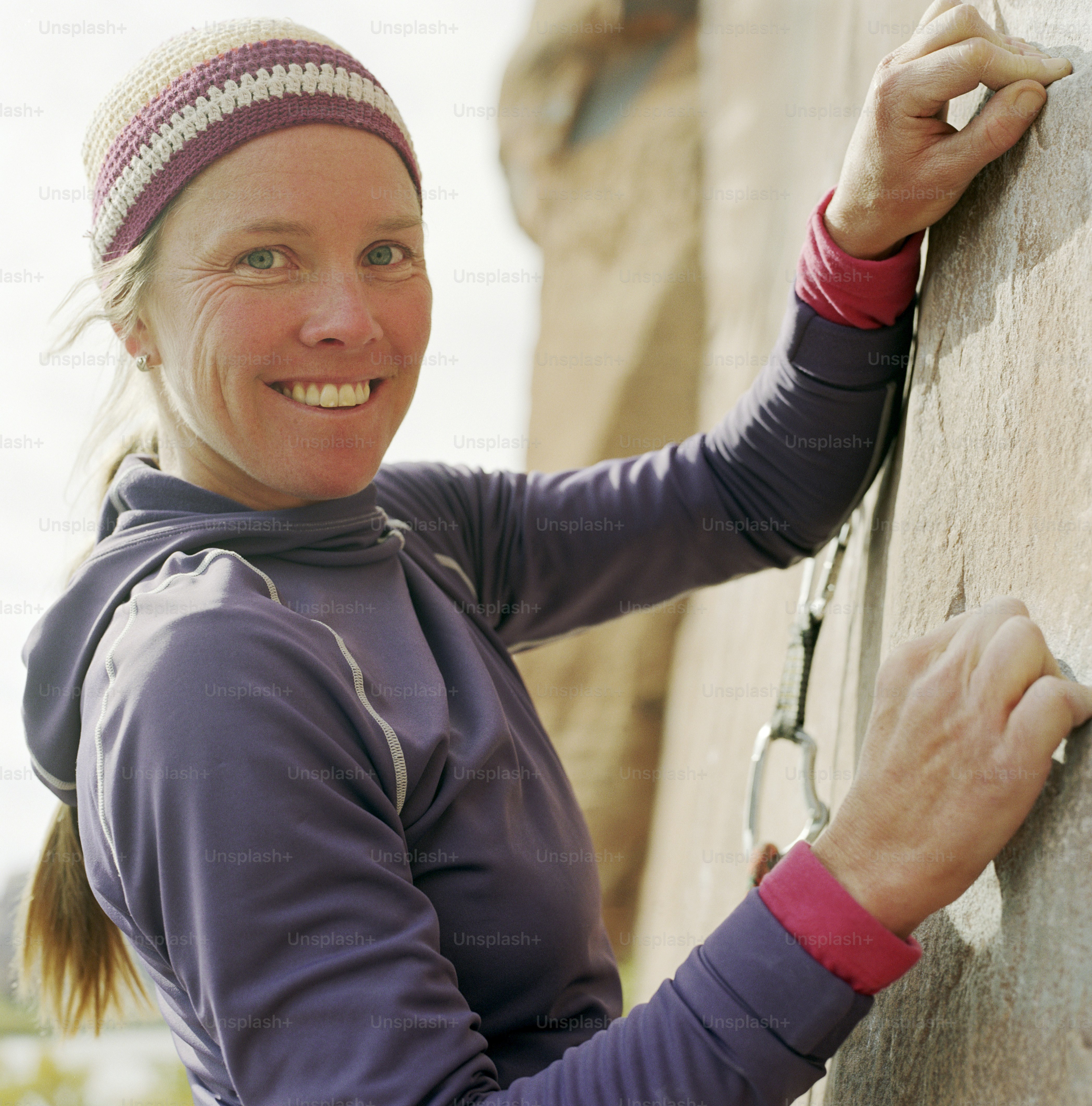 Female rock climber on rock face, smiling, portrait (selective focus ...