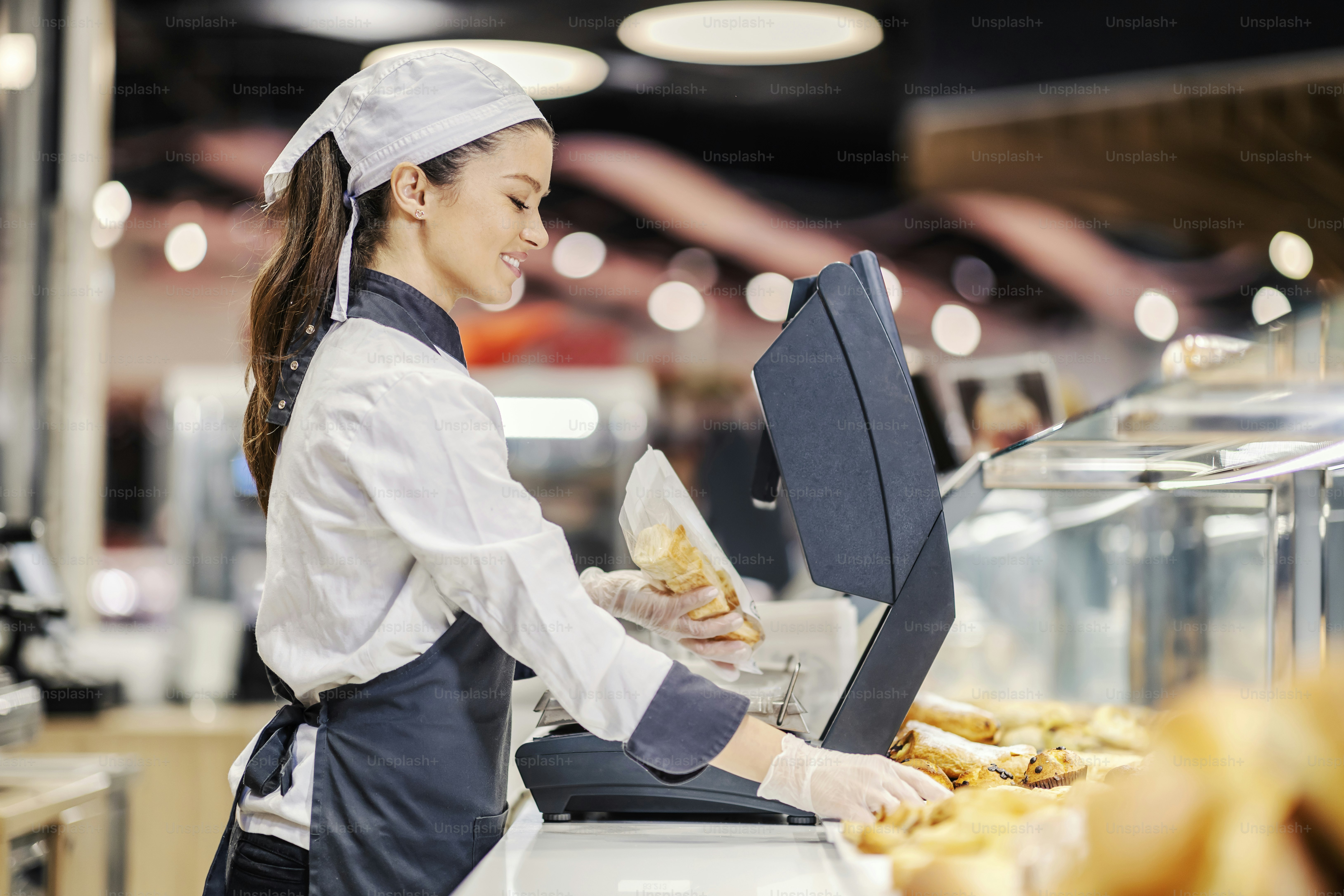 A bakery department worker in supermarket selling pastry. photo – Food ...