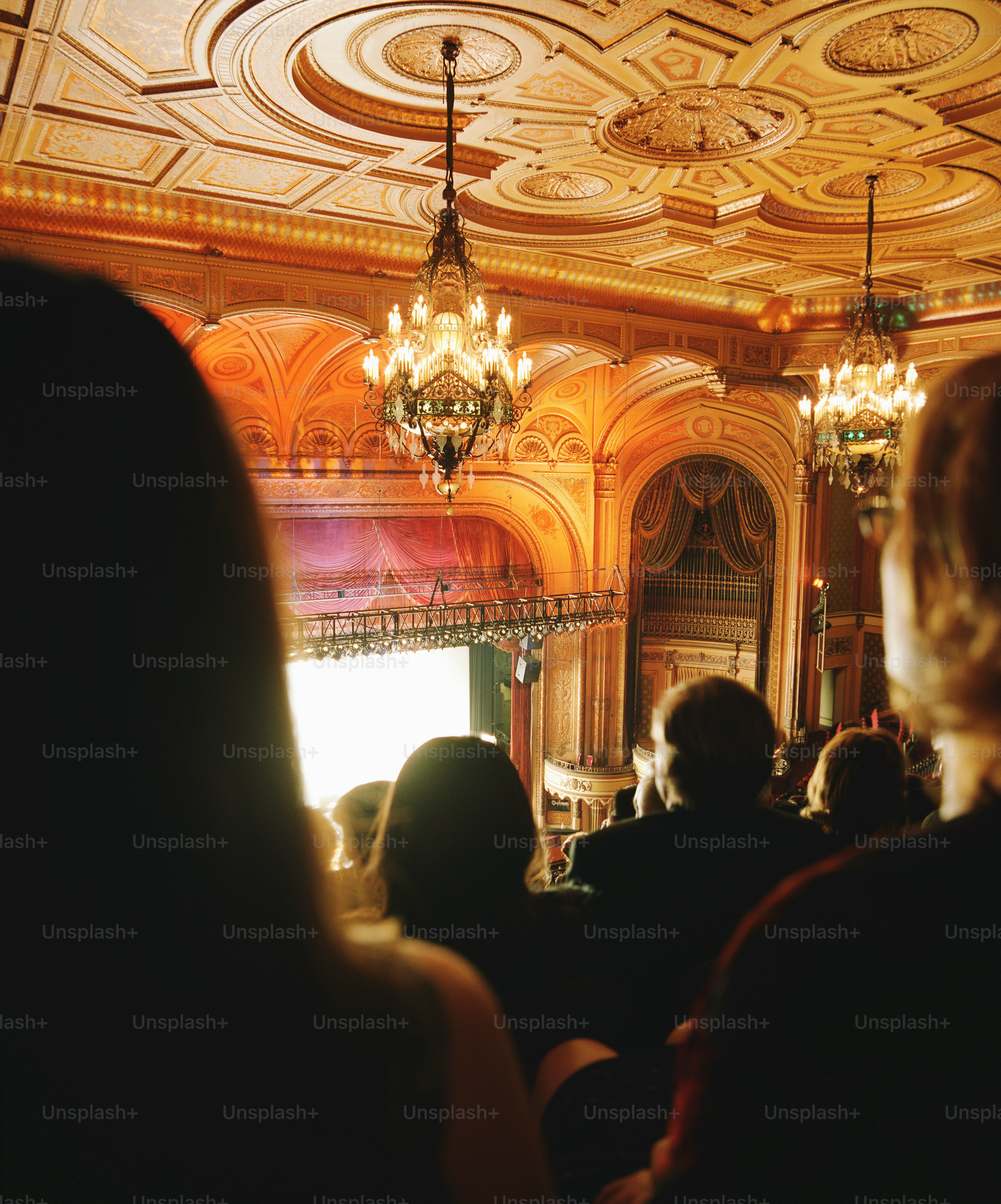 A group of people in a room with chandeliers photo – Lightroom Image on ...