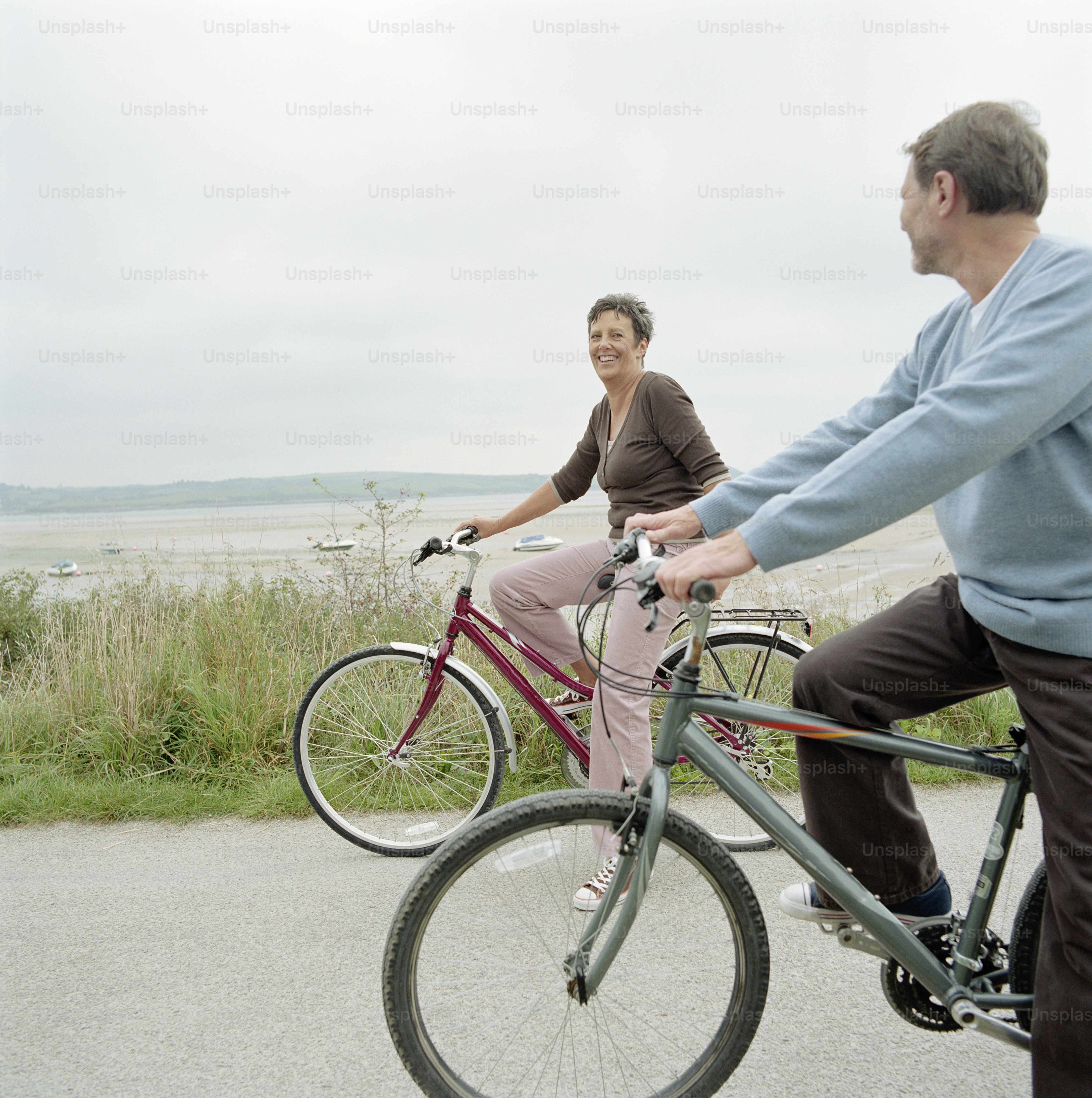 A man and a woman riding bikes on a road photo – Bicycle Image on Unsplash