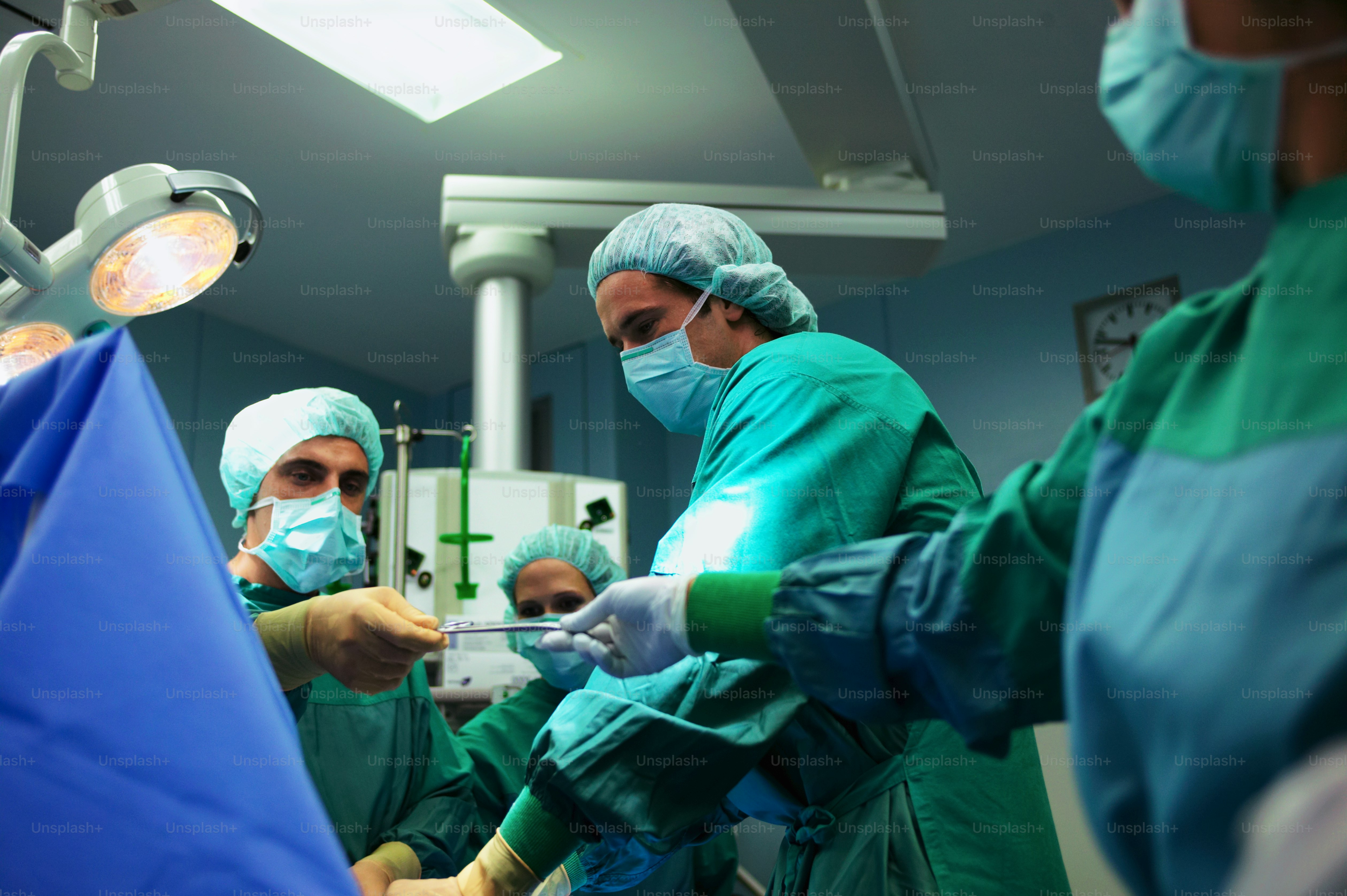 A group of doctors performing surgery in an operating room photo ...