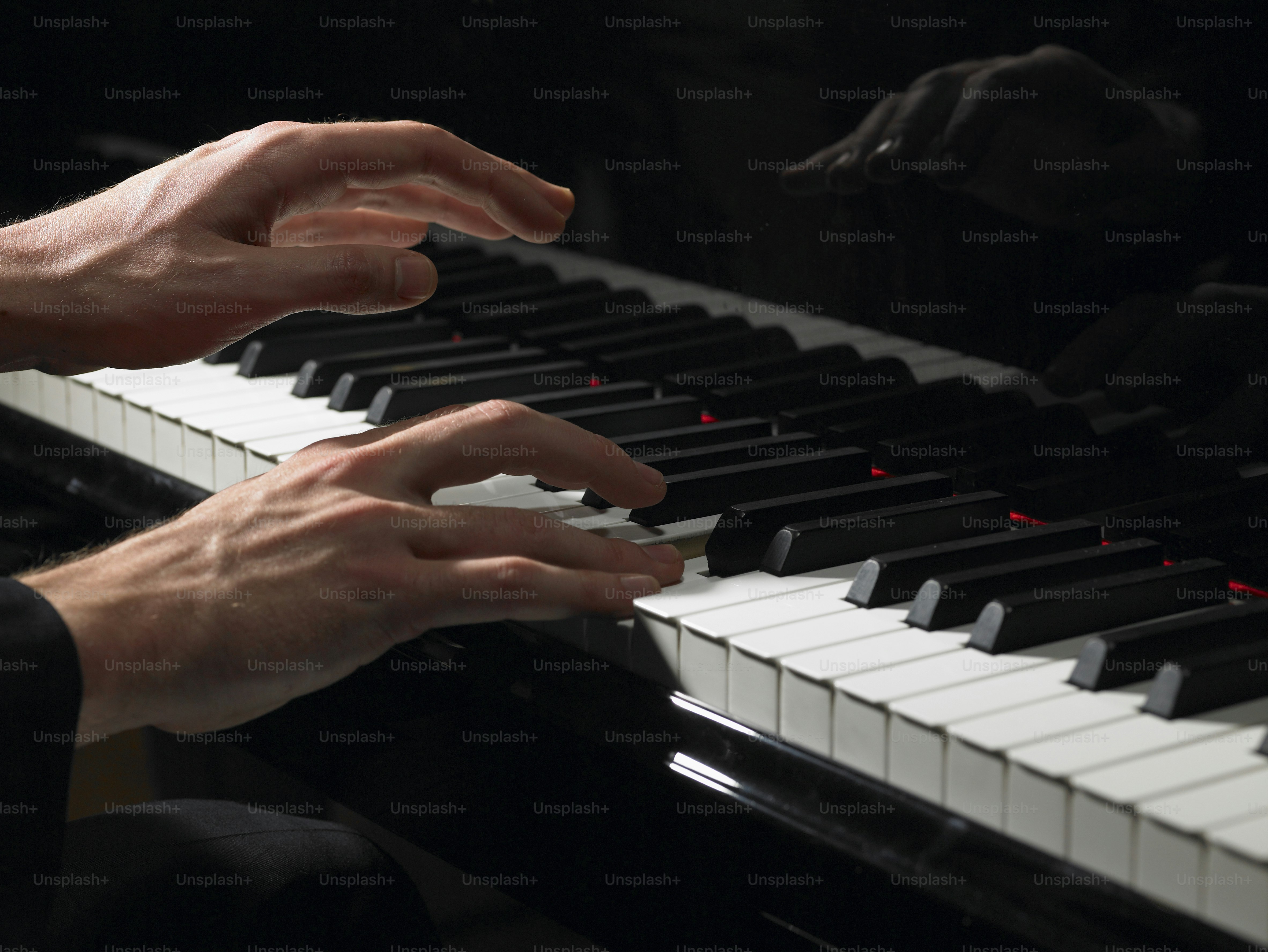 A person playing a piano with their hands photo – Piano key Image on ...